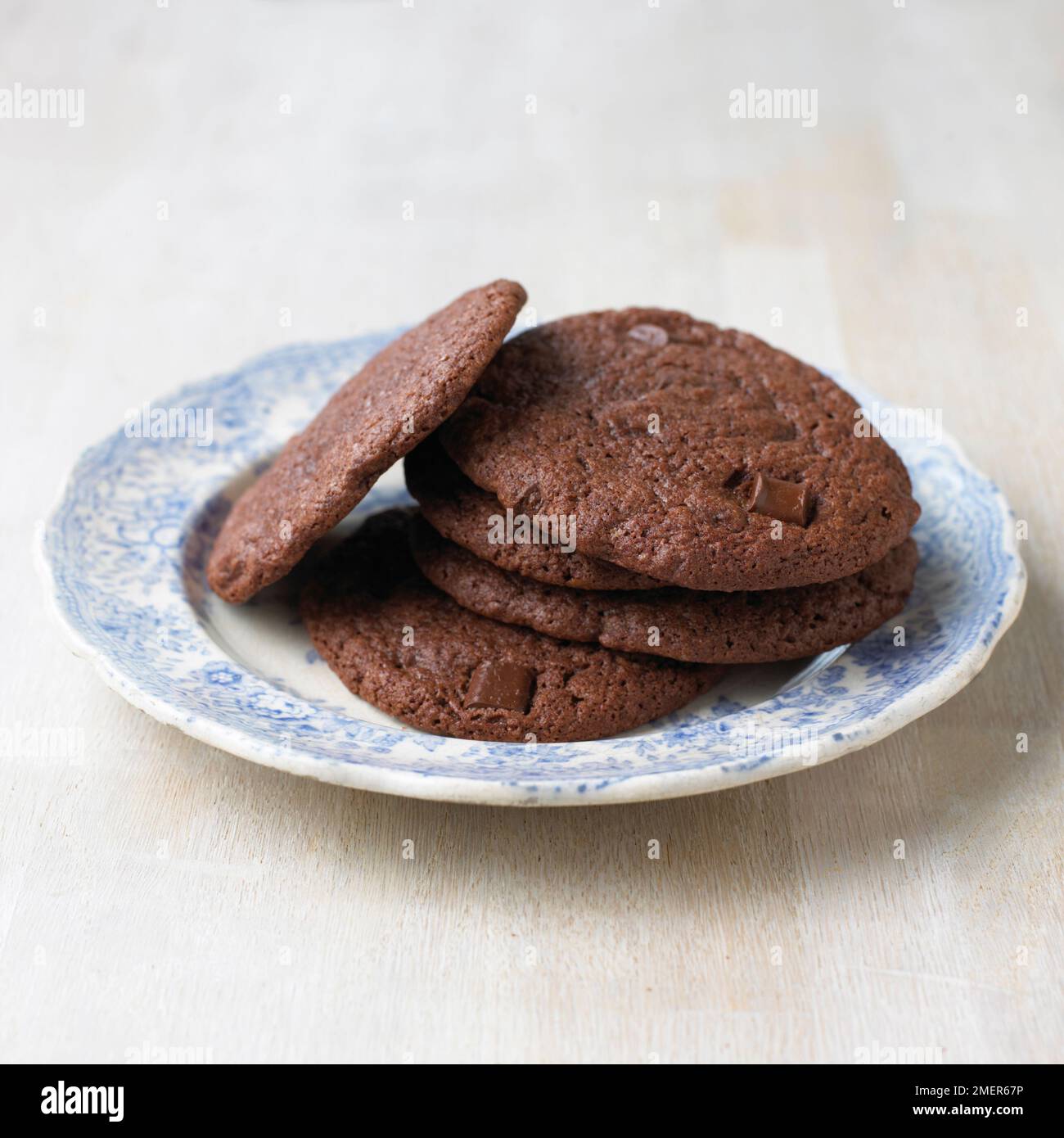 Three chocolate chip cookies and glass of milk Stock Photo - Alamy