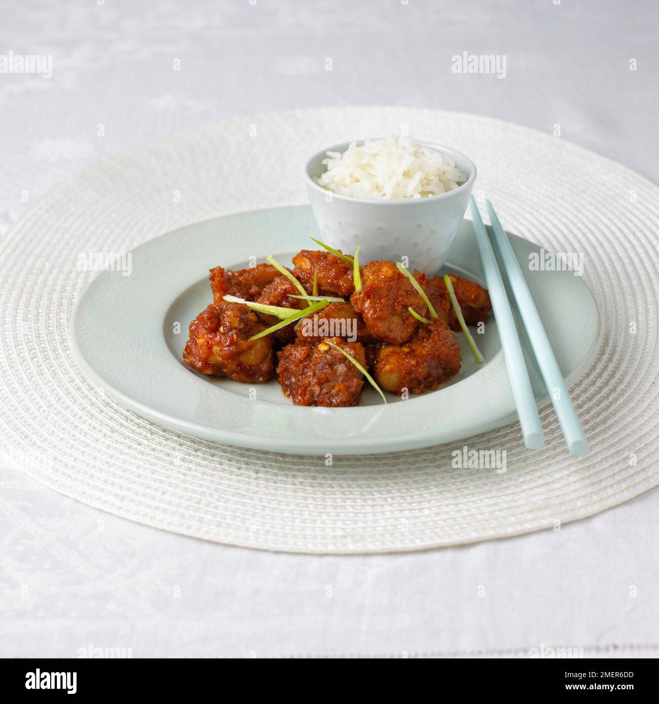 General Tso's chicken served on bed of rice, chopsticks Stock Photo - Alamy