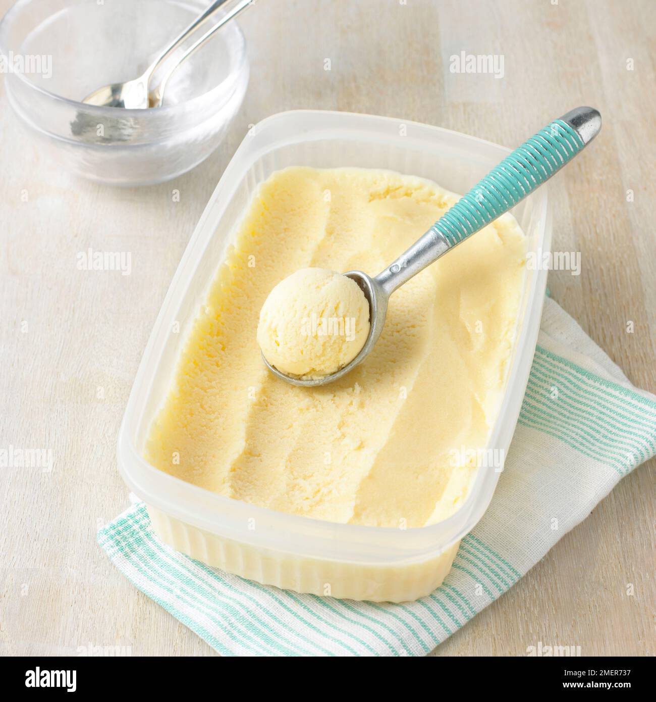 Tub of vanilla ice cream and scoop Stock Photo - Alamy