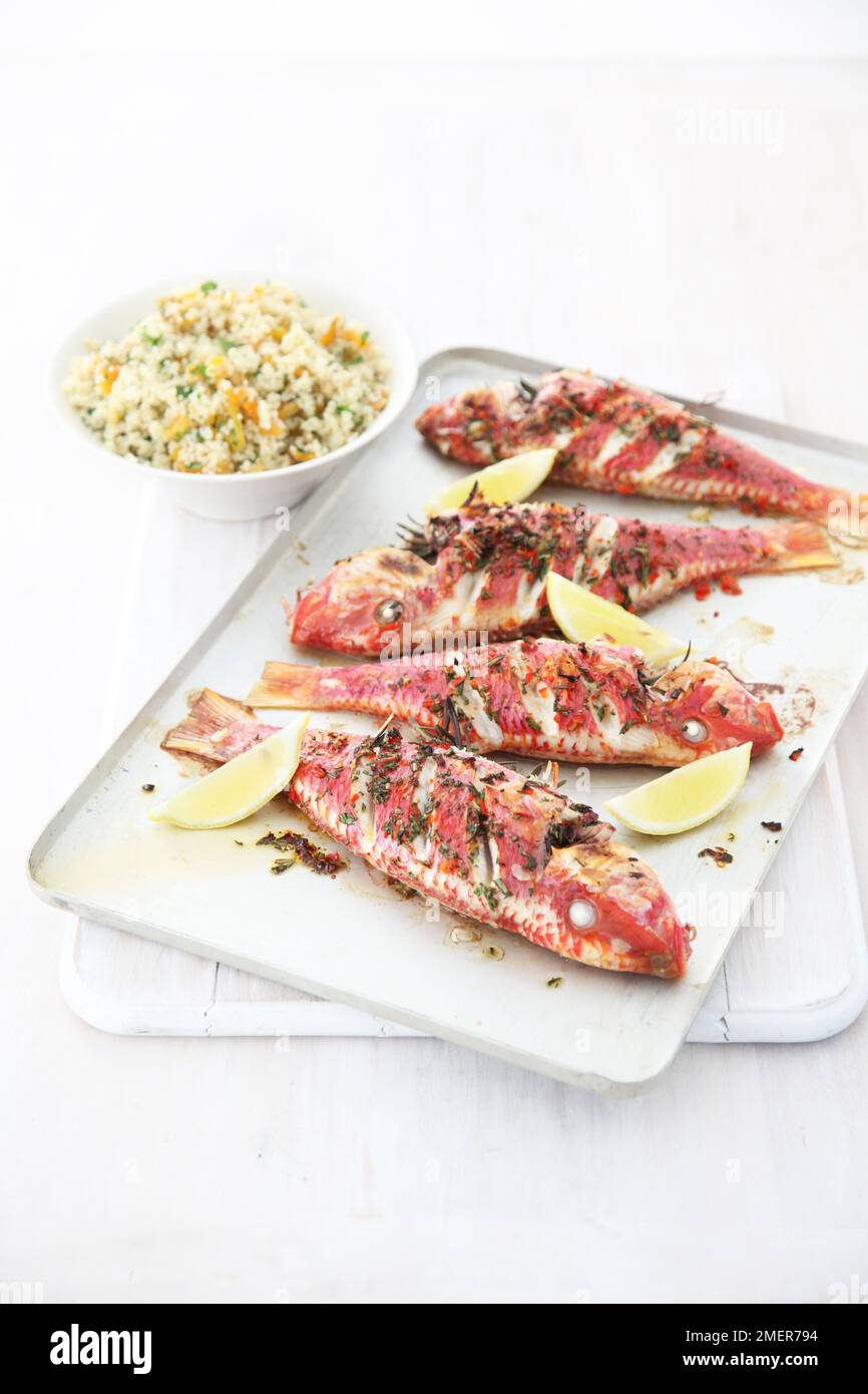 Grilled red mullet, lemon wedges and rice salad Stock Photo - Alamy