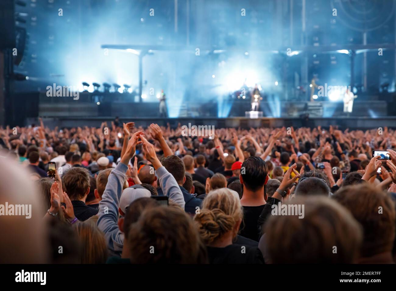 The happy crowd in a concert hall. Silhouettes of raised hands Stock ...