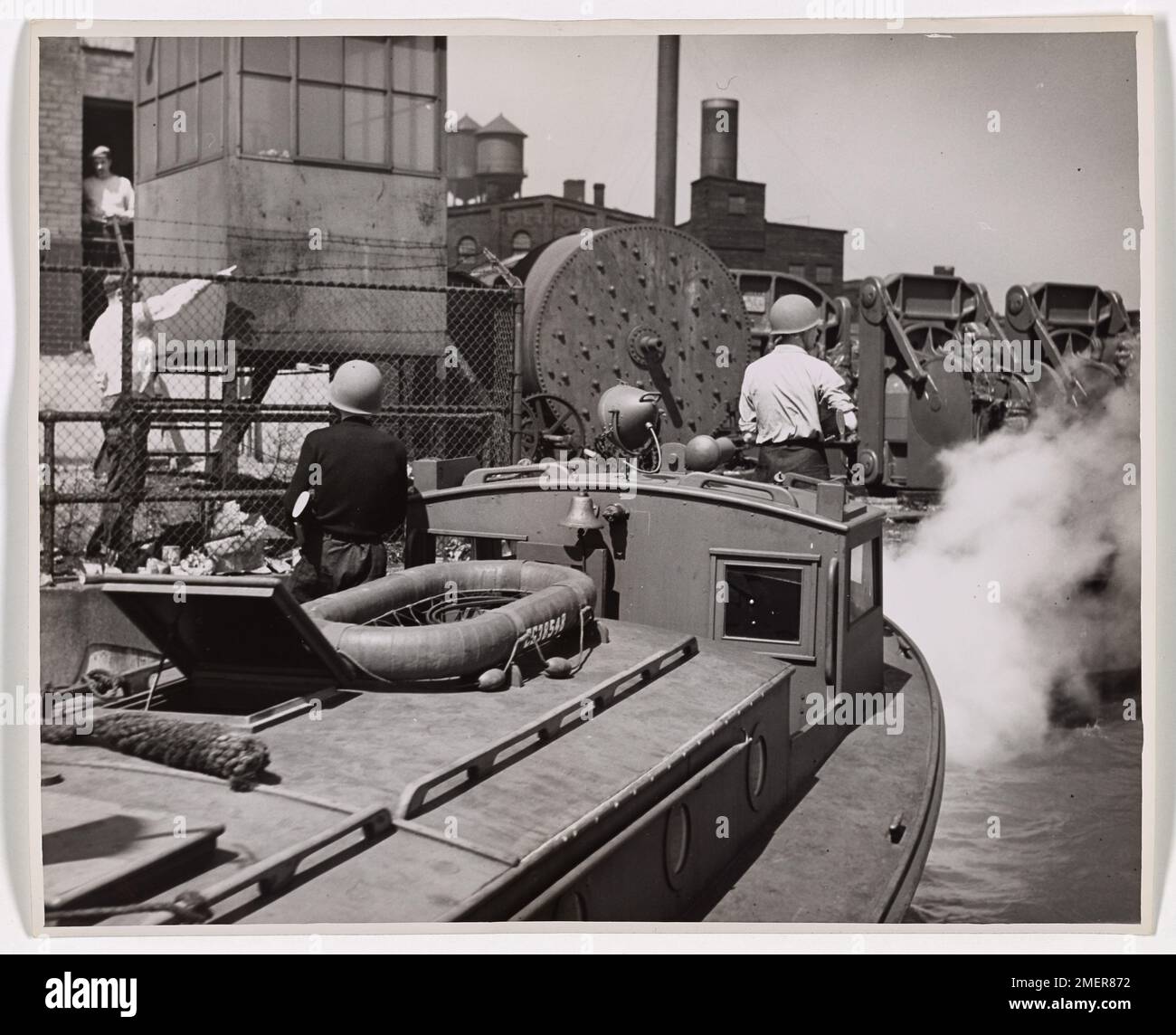 Photograph of Picket Boat Approaching a Water Front War Plant. An ...
