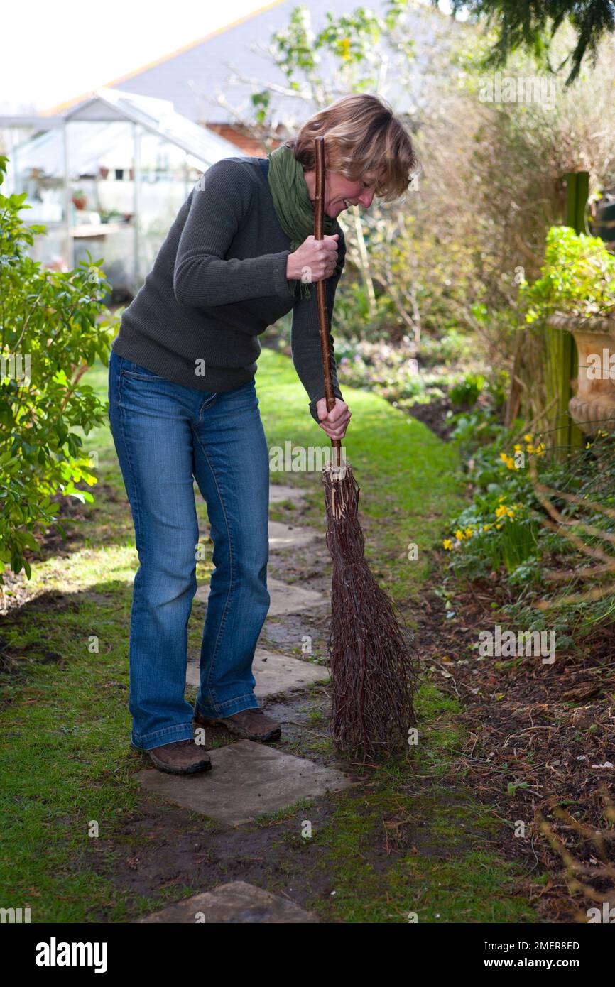 Woman using besom broom on lawn, removing worm casts Stock Photo - Alamy