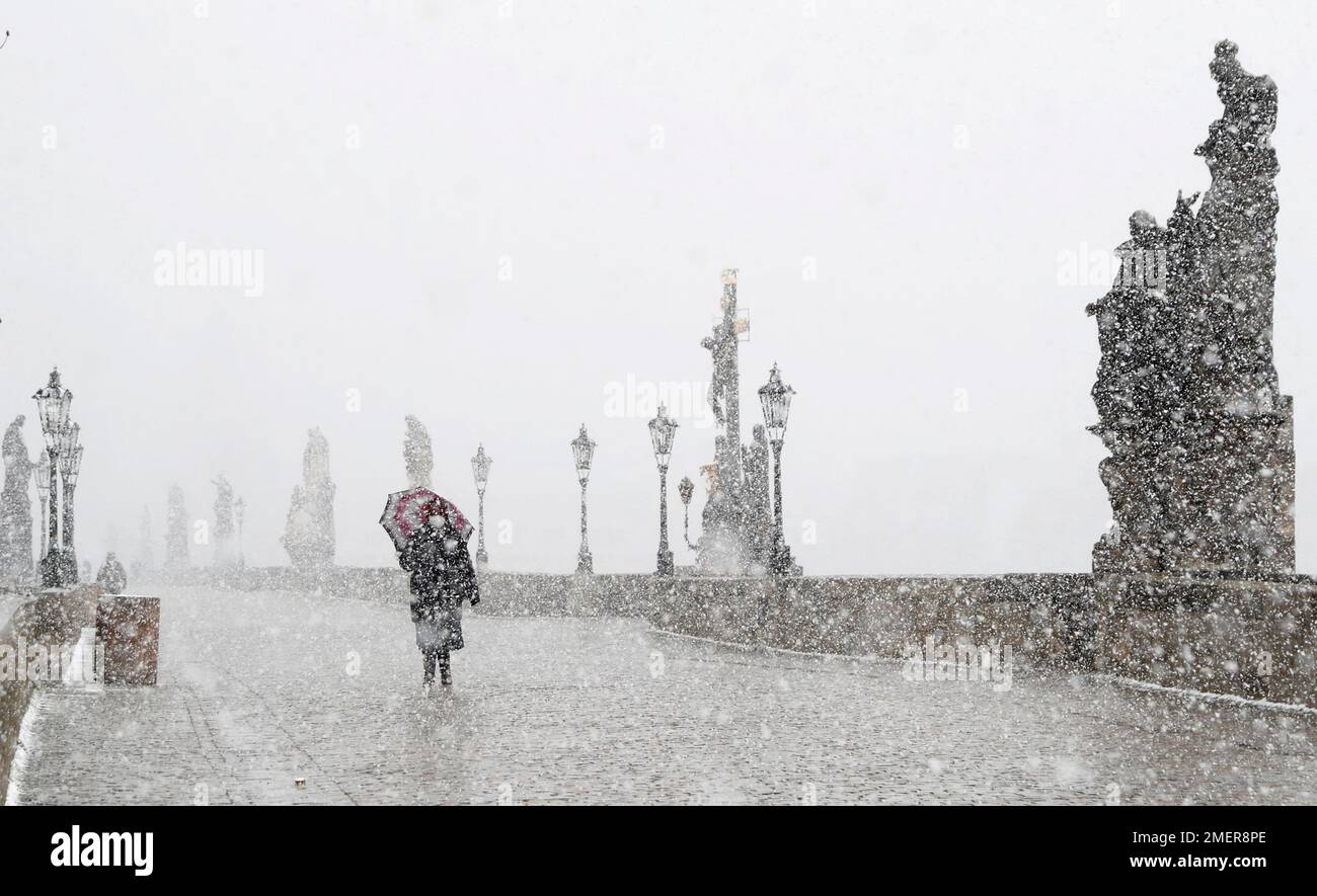 A woman braves a snowstorm crossing the medieval Charles Bridge in ...