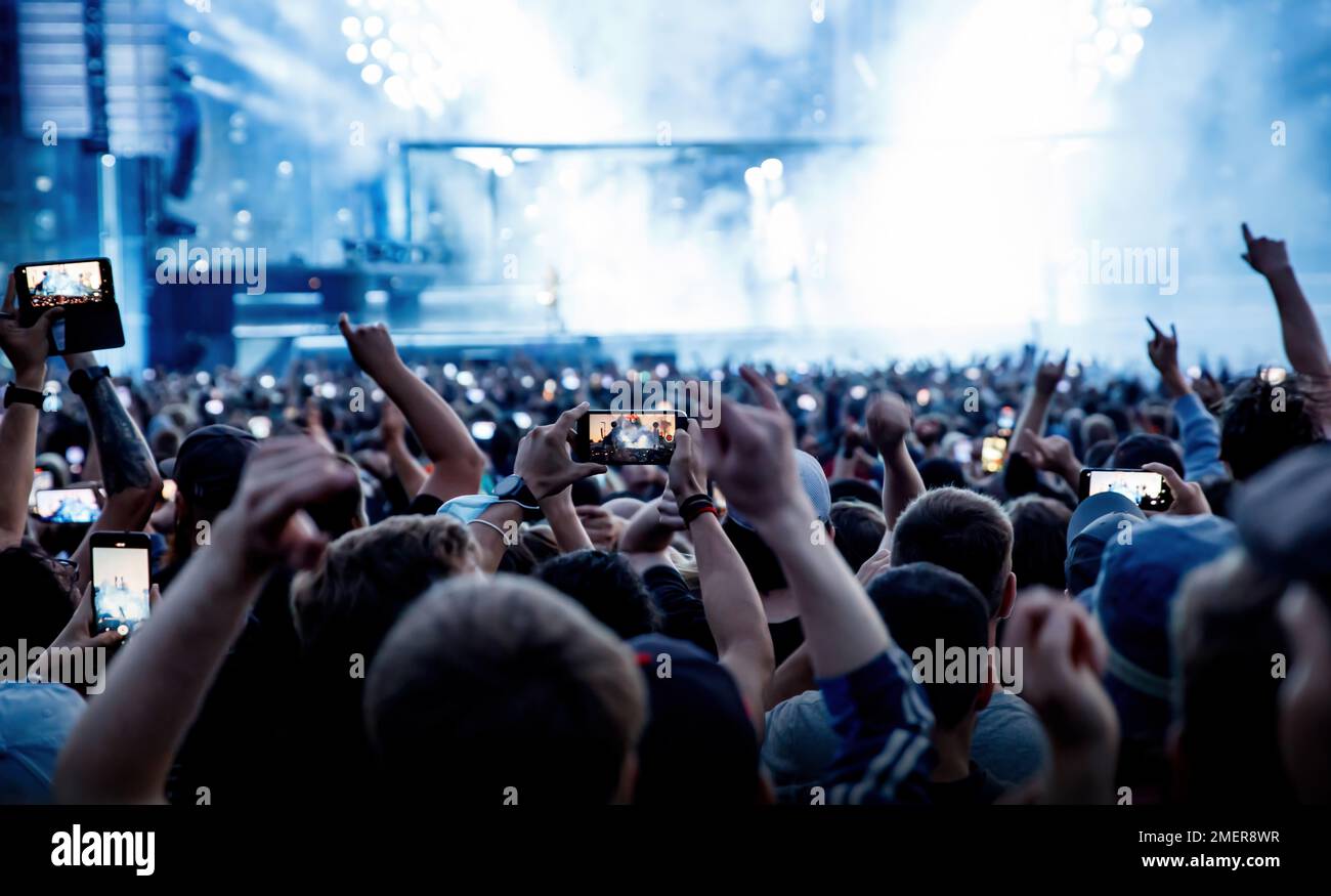 The happy crowd in a concert hall. Silhouettes of raised hands Stock ...