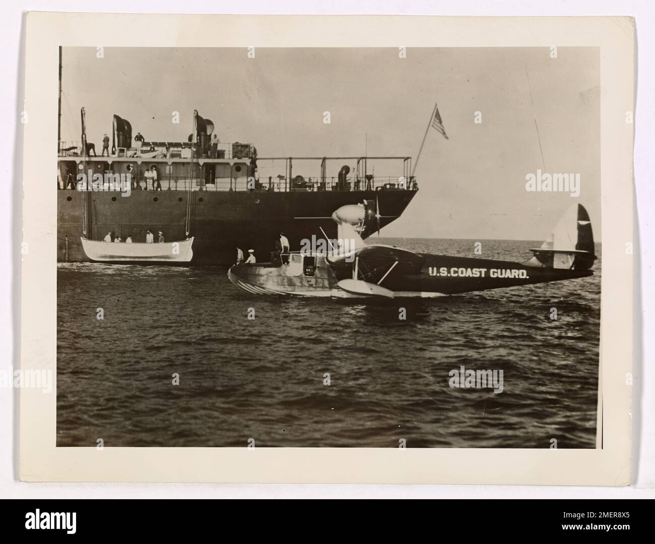 This image shows a Coast Guard plane on the water, likely a seaplane ...