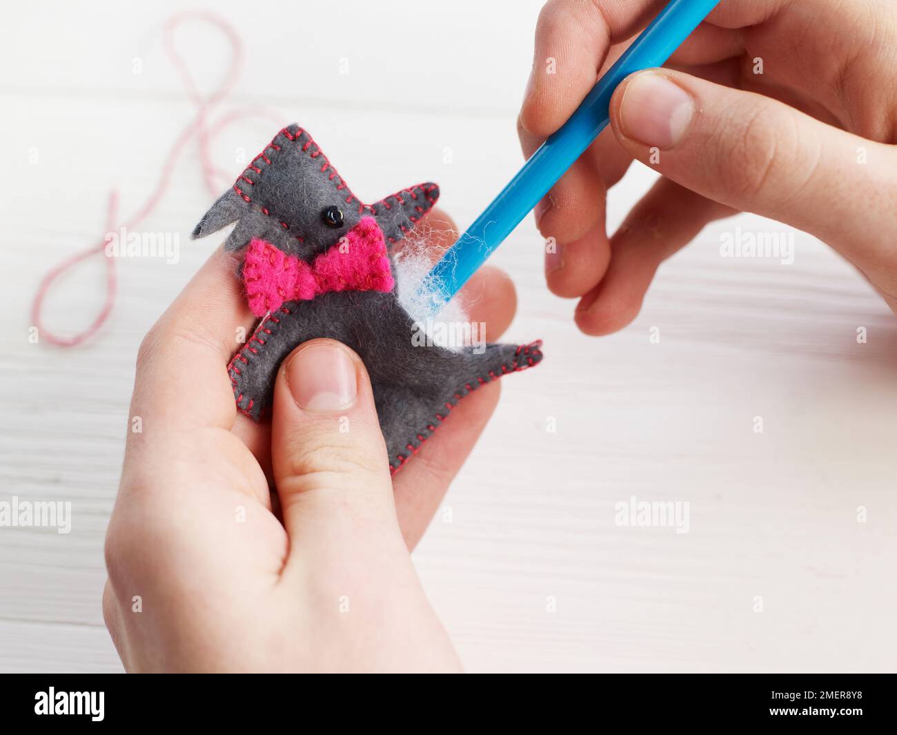 Making felt dog badge, stuffing the filling into the body Stock Photo ...