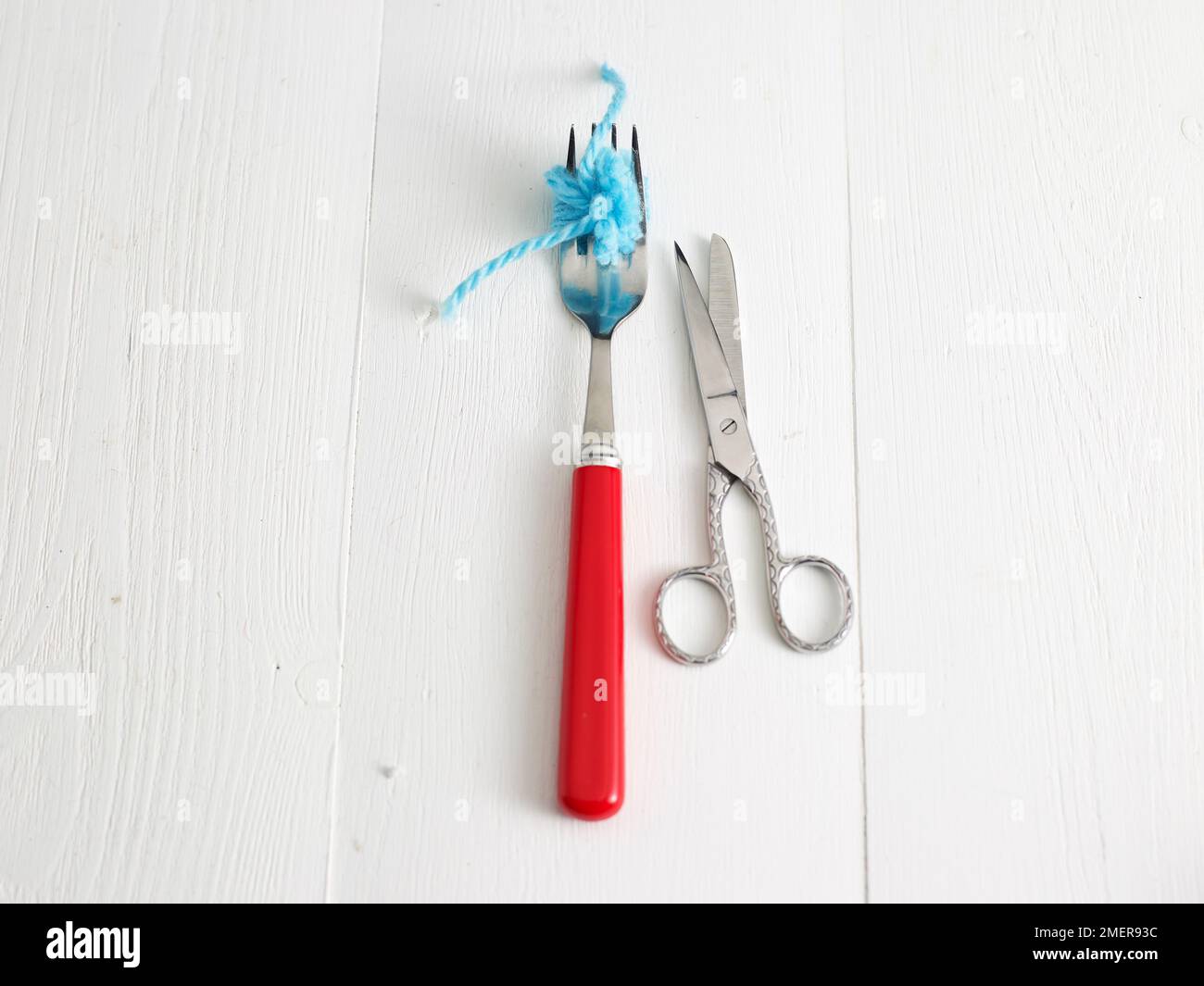 Making speedy mini pom-poms, wrapping wool around fork in layers and ...