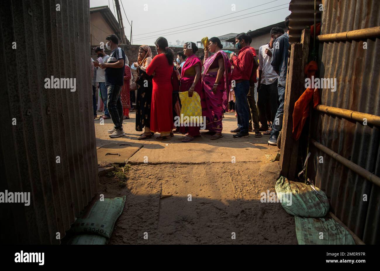 People stand in queue to cast their votes outside a polling station ...