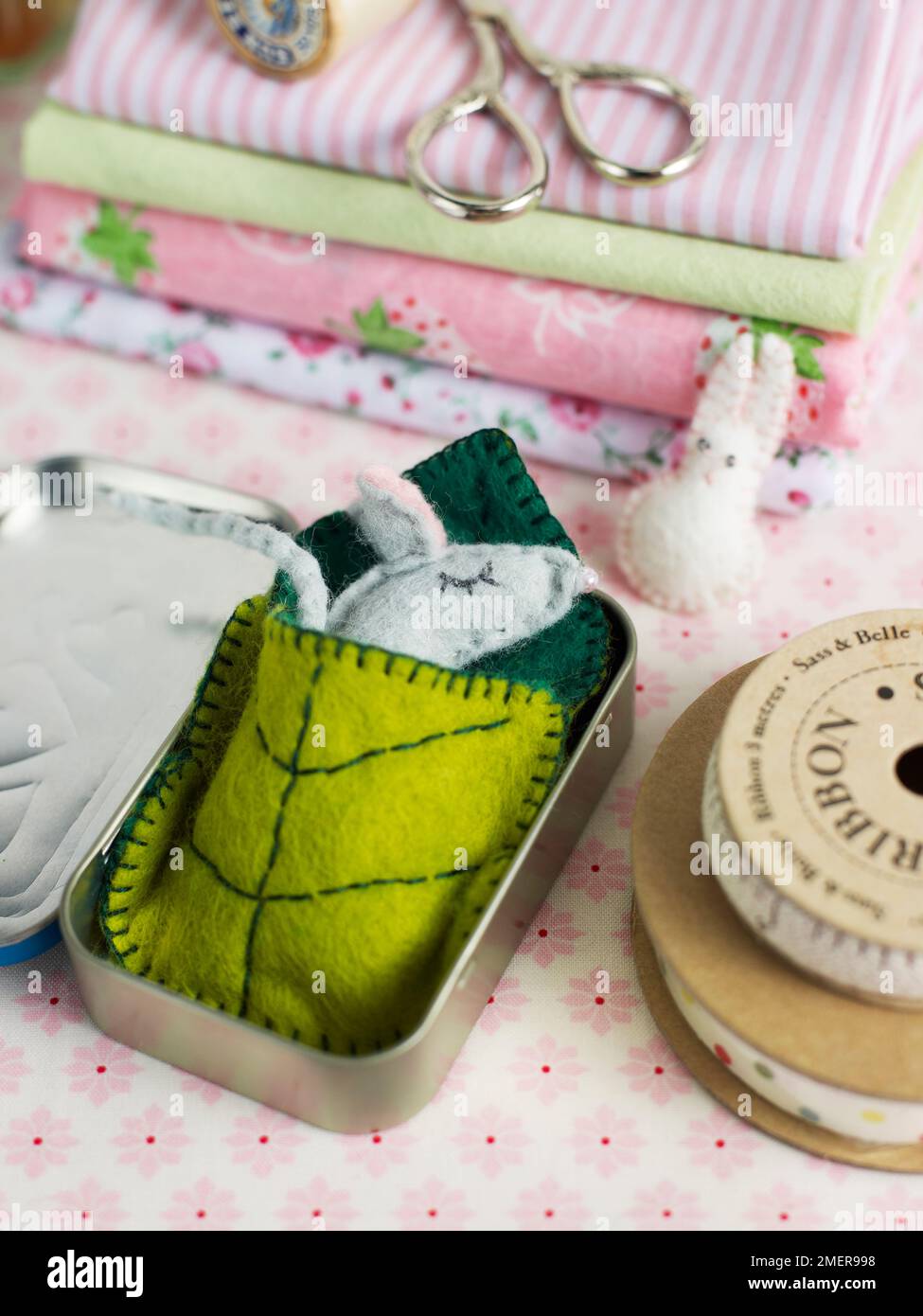Felt mouse in tin surrounded by fabrics and craft materials Stock Photo ...