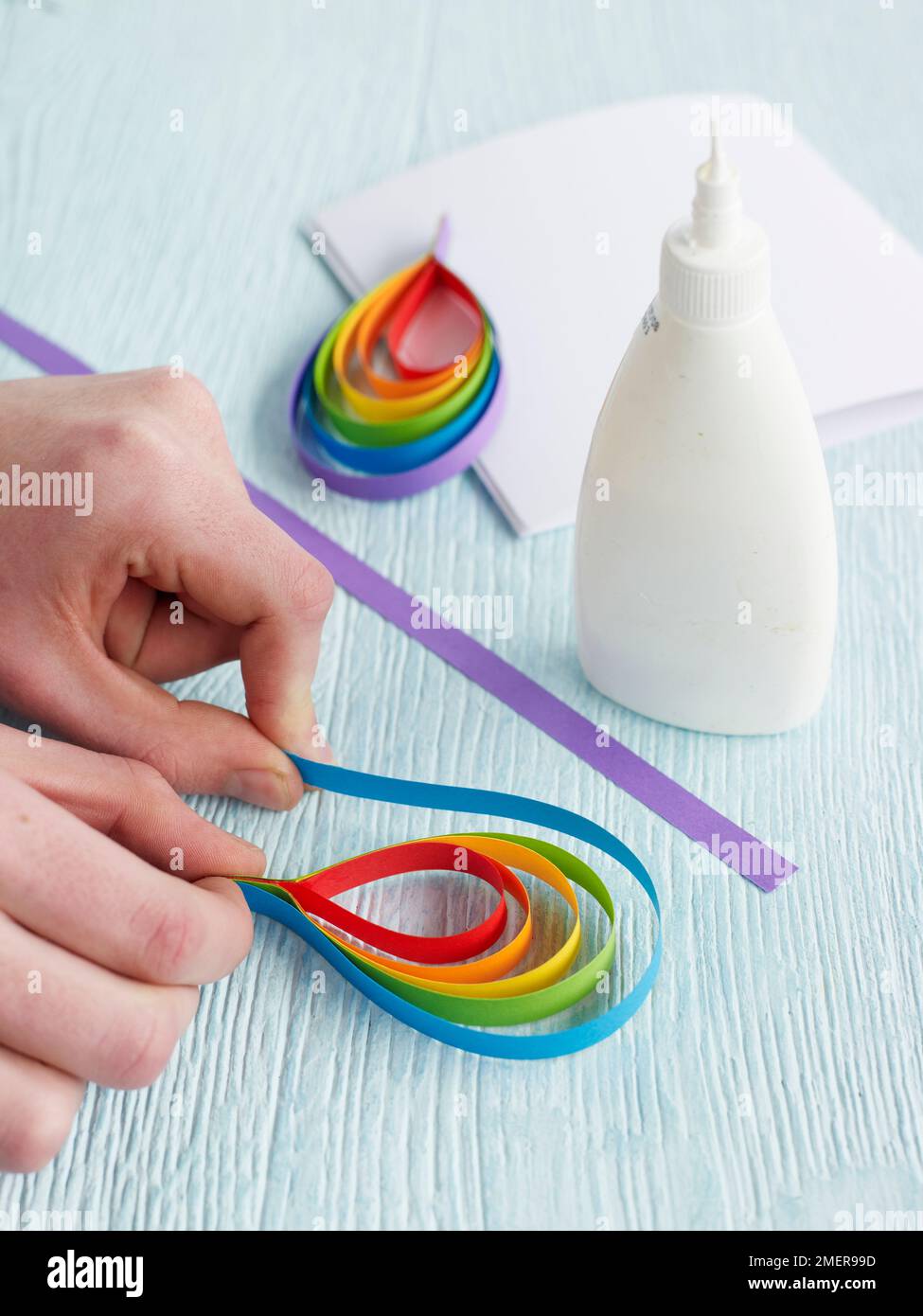 Making a heart card, Bending colourful strips into loops to make heart ...