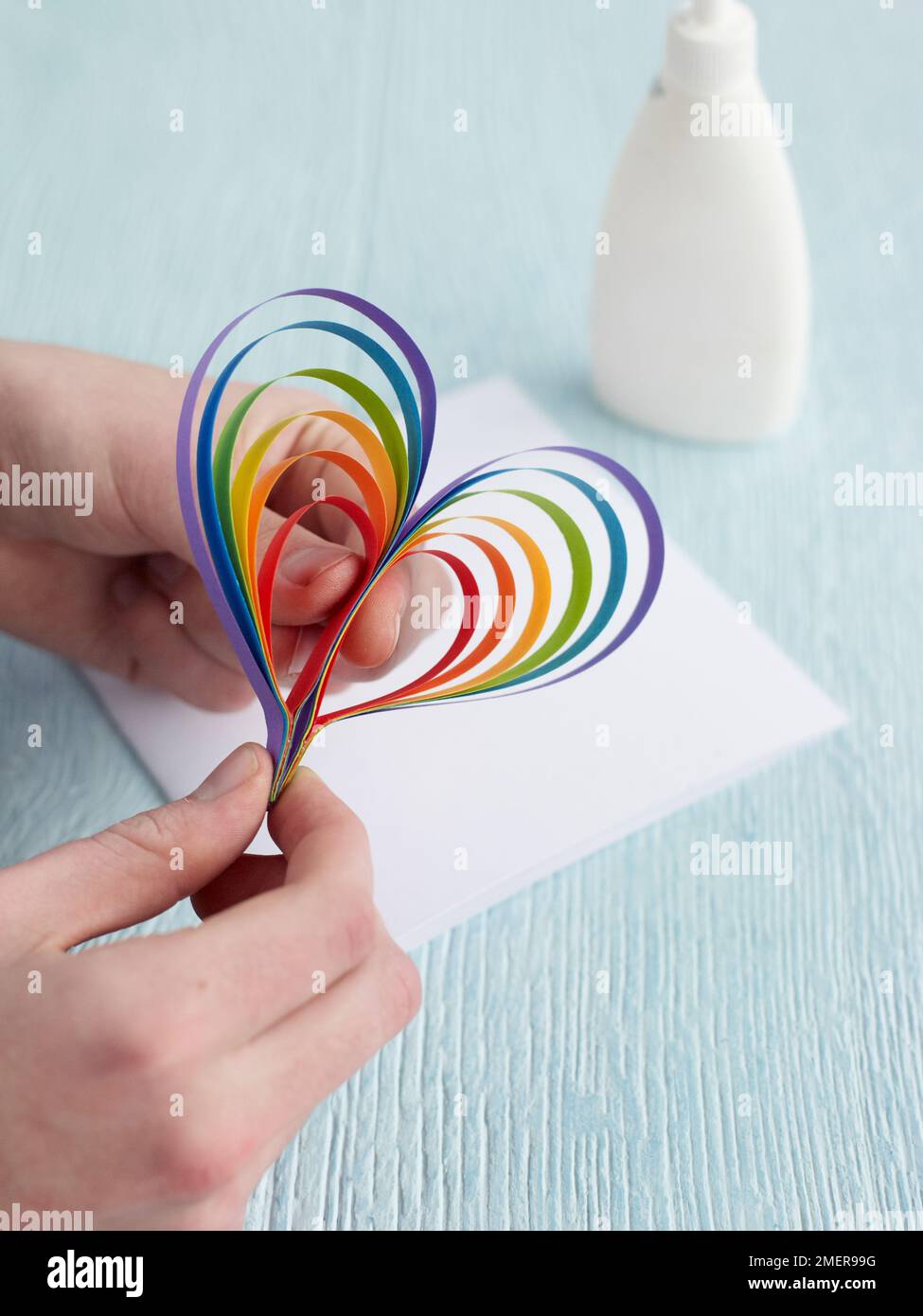 Making a heart card, Bending colourful strips into loops to make heart ...