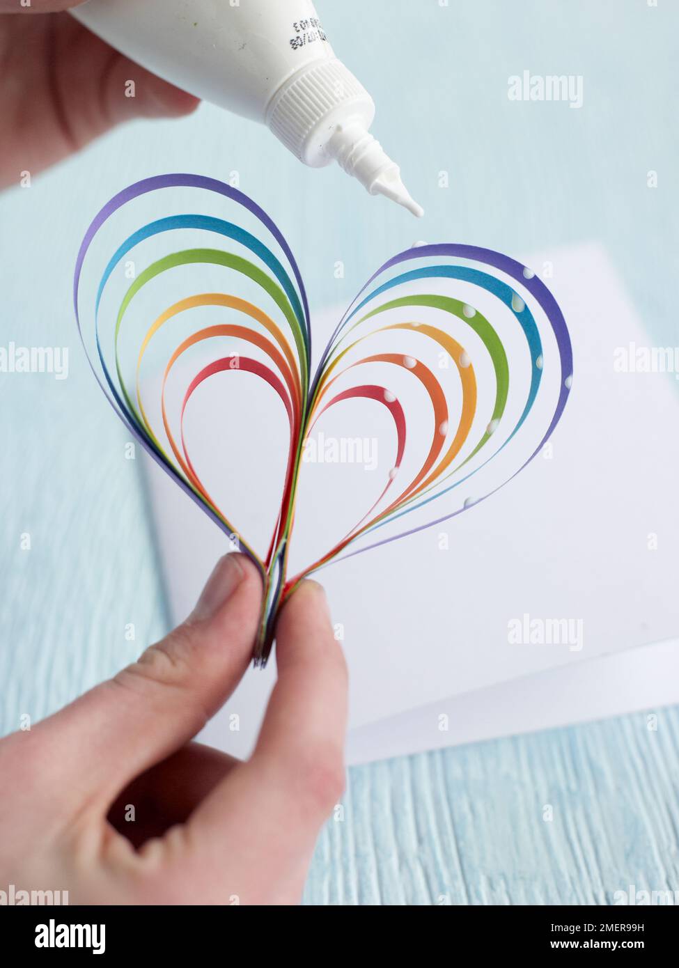 Making a heart card, Bending colourful strips into loops to make heart ...