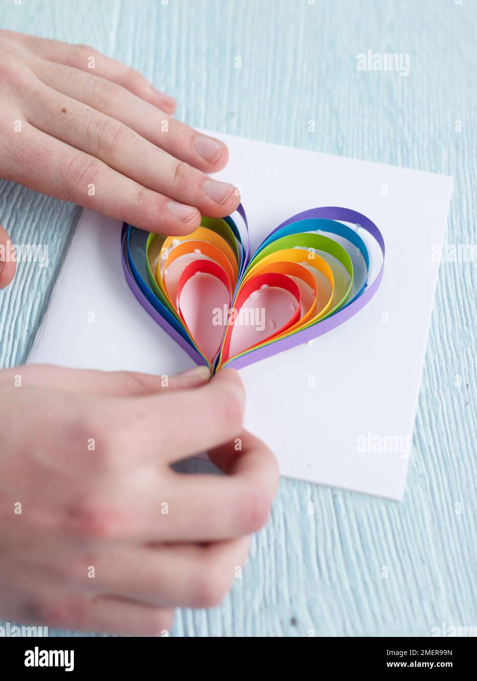 Making a heart card, Bending colourful strips into loops to make heart ...