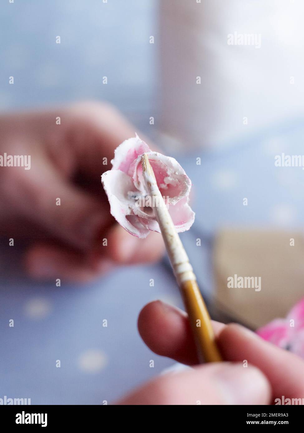 Making plaster flowers, using paintbrush to cover exposed parts of the ...