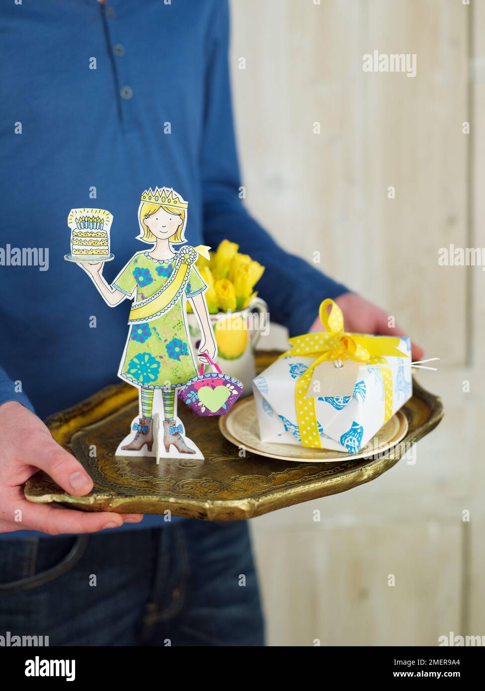 Man carrying serving tray with present, paper cut out figure holding ...