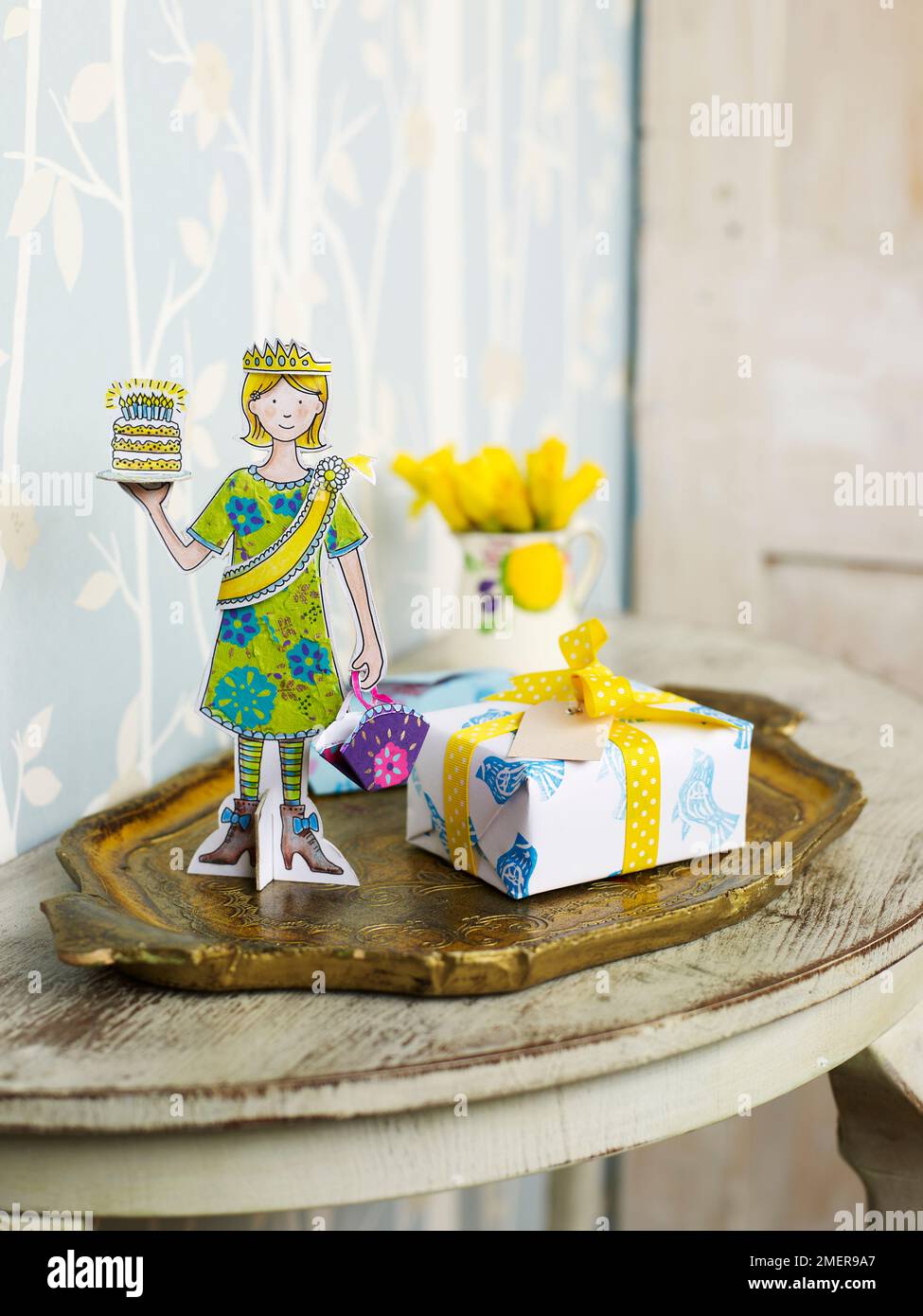 Serving tray with present, paper cut out figure holding cake, and ...