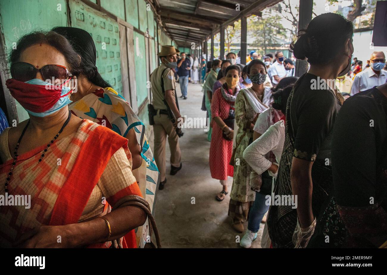 People stand in queue to cast their votes in a polling station during ...