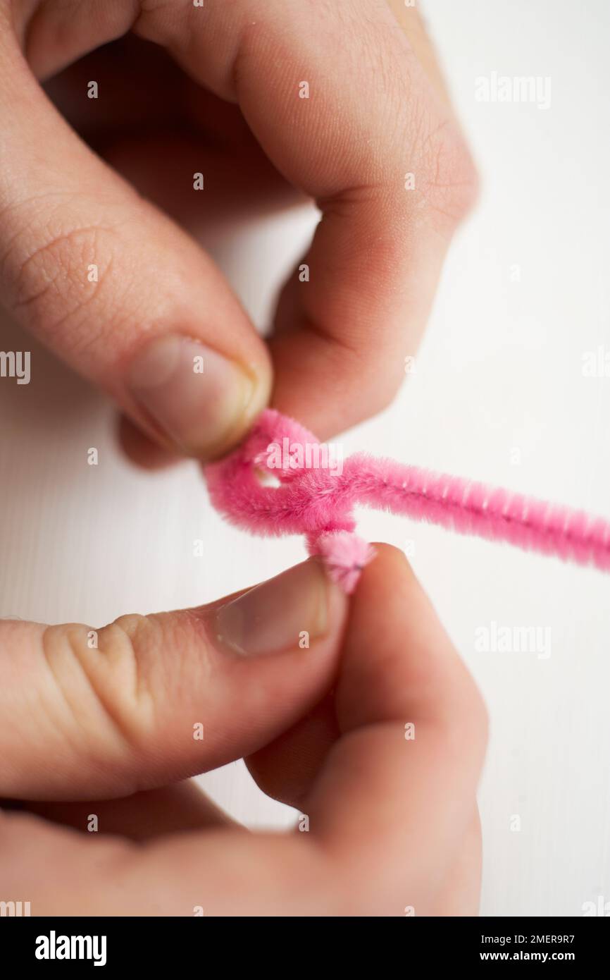 Making small loop from pink pipe cleaner Stock Photo - Alamy