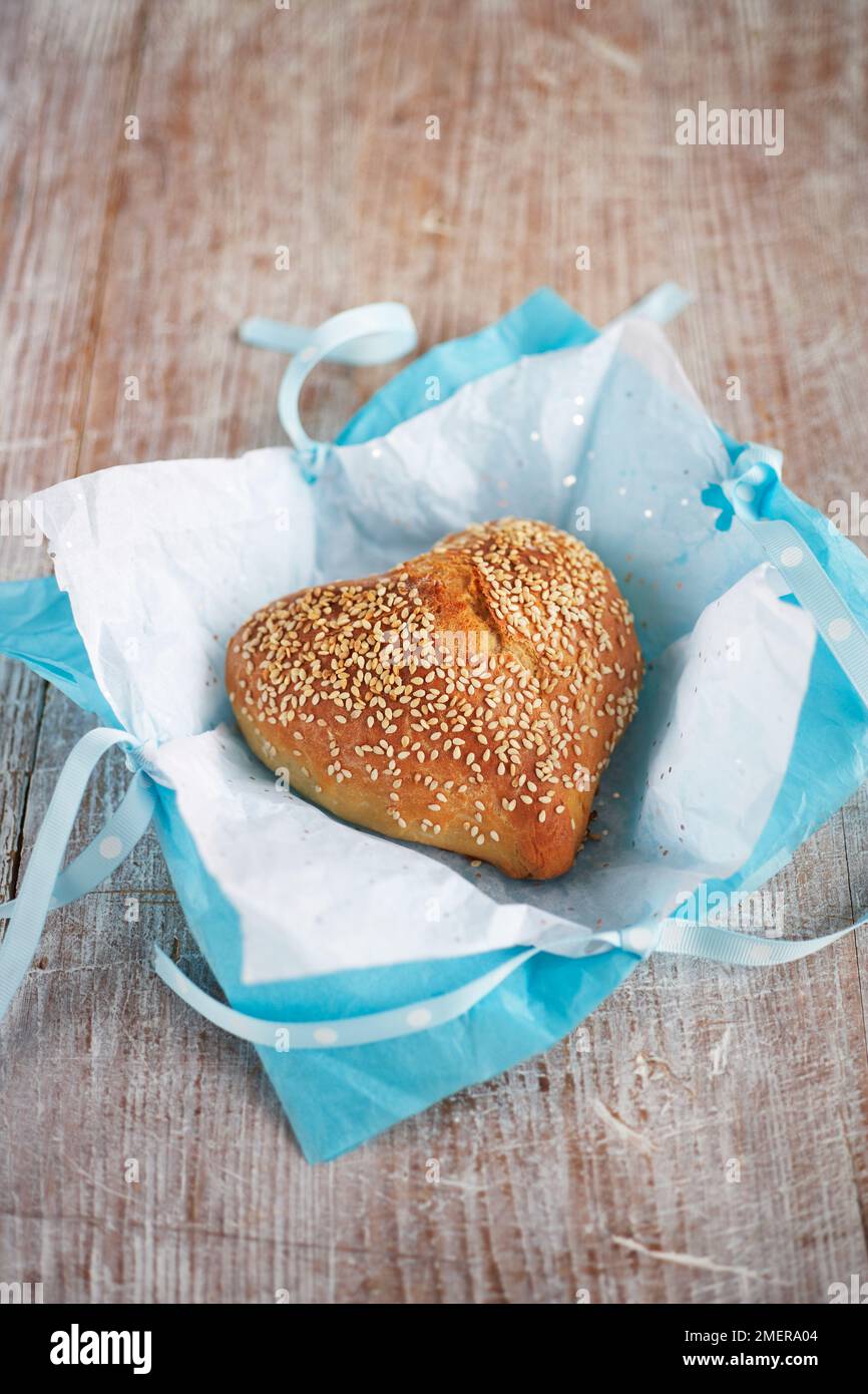 Heart shaped sesame seed bread roll on wrapping paper Stock Photo - Alamy