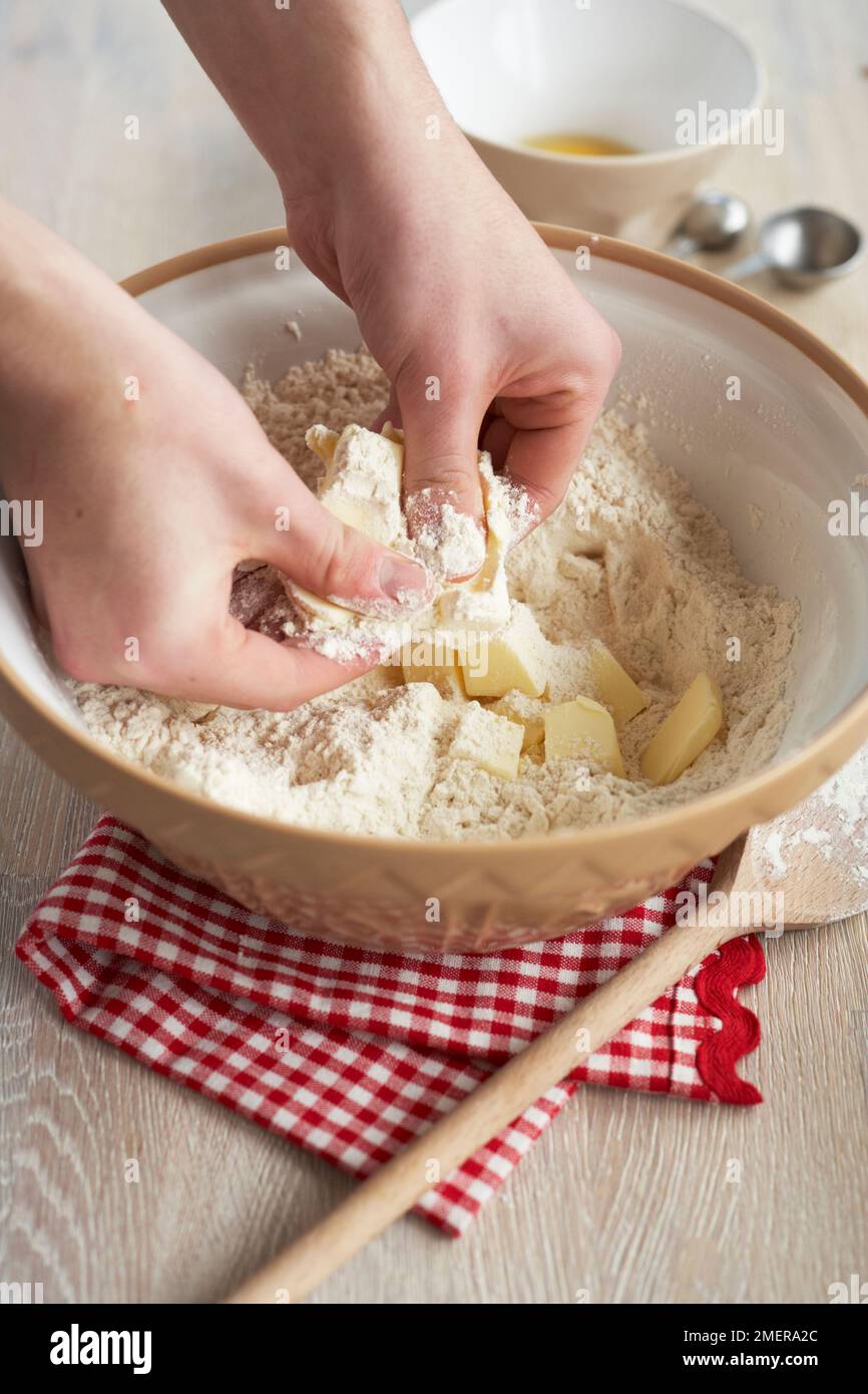 Rubbing butter into flour mixing, making gingerbread biscuits Stock ...