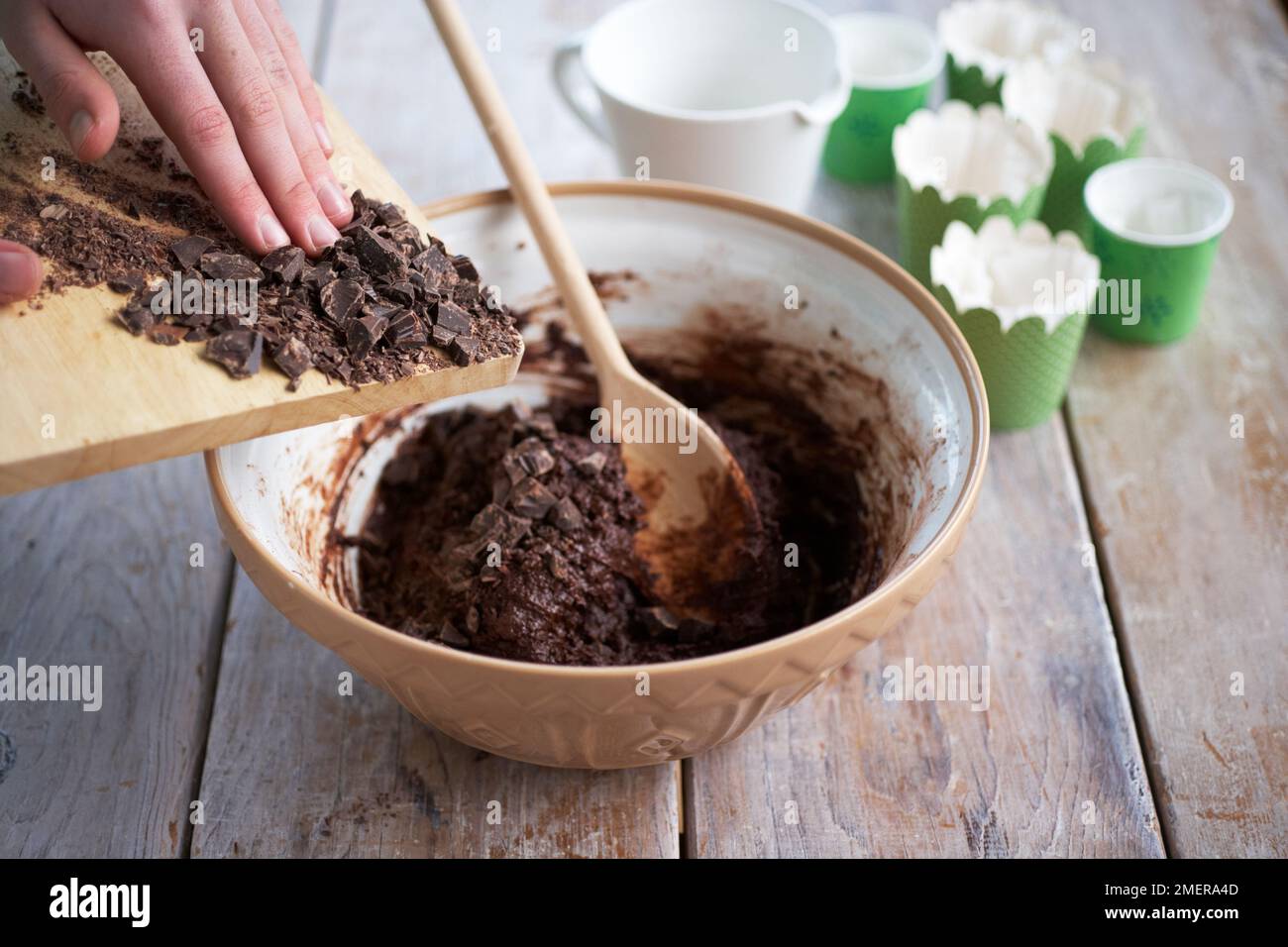 Adding chocolate chunks to mixture, making flowerpot cakes Stock Photo ...
