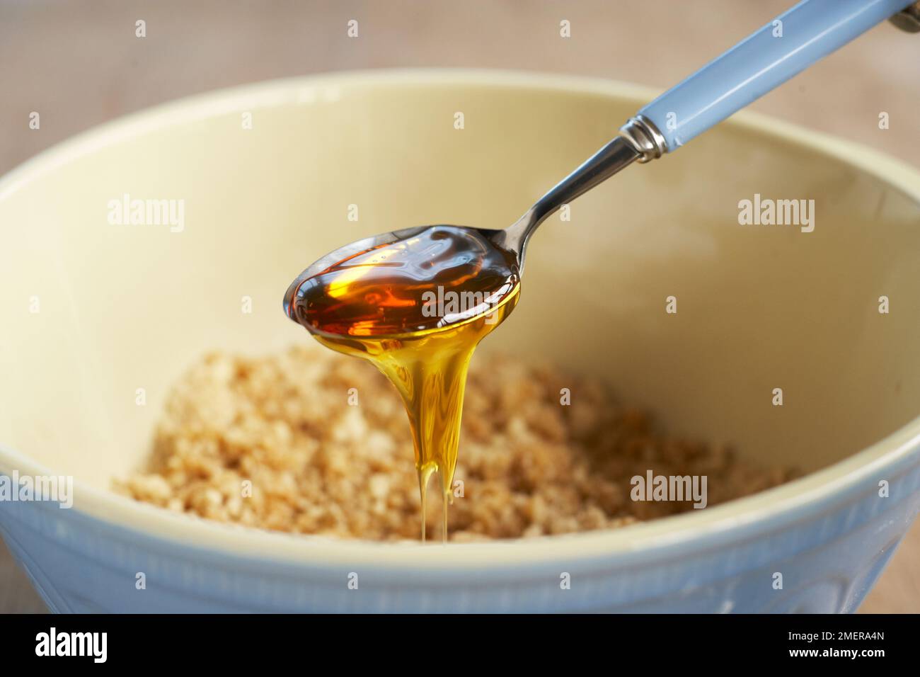 Adding golden syrup to mixture, making biscuit dough Stock Photo - Alamy
