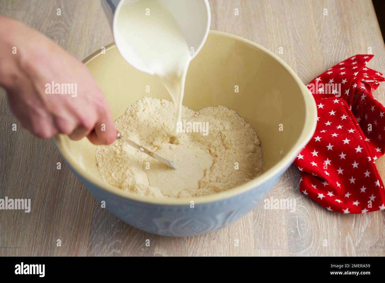 Pouring milk into mixture Stock Photo - Alamy