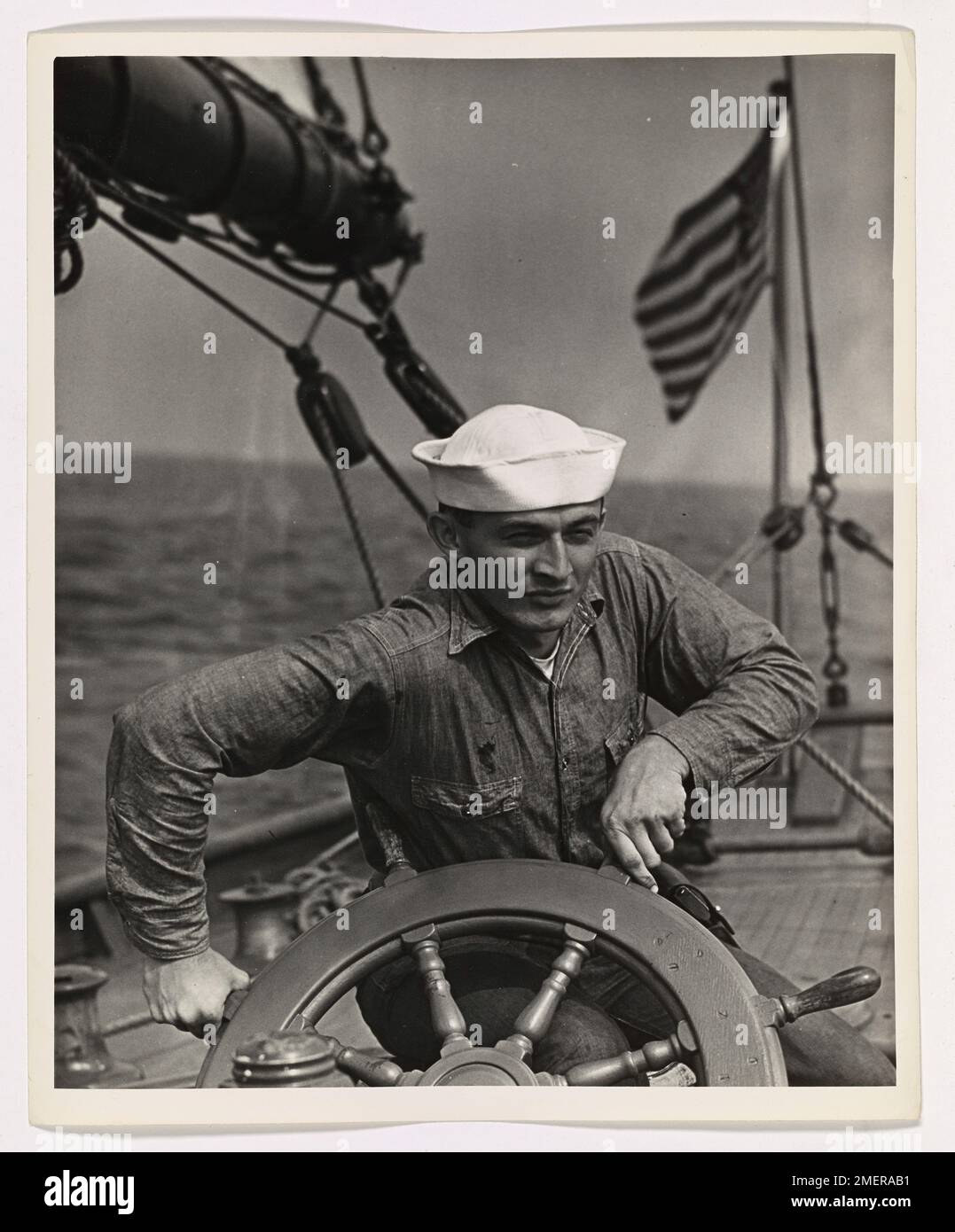 A Coast Guardsman serves as the helmsman on a schooner during an anti ...