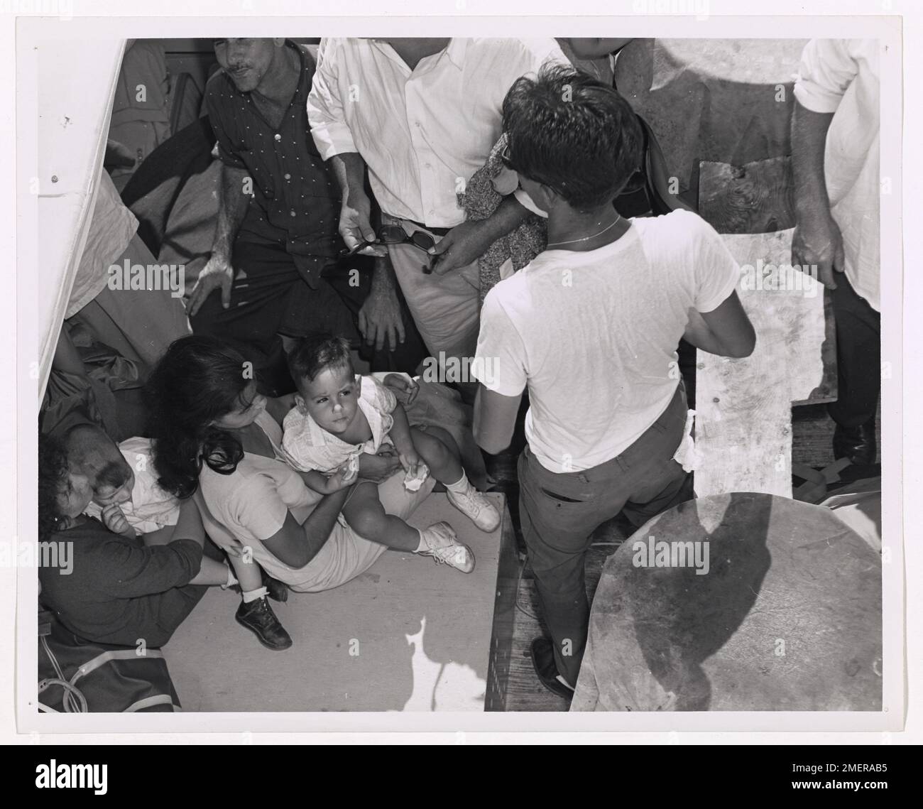 This photograph depicts refugees with children during a humanitarian ...