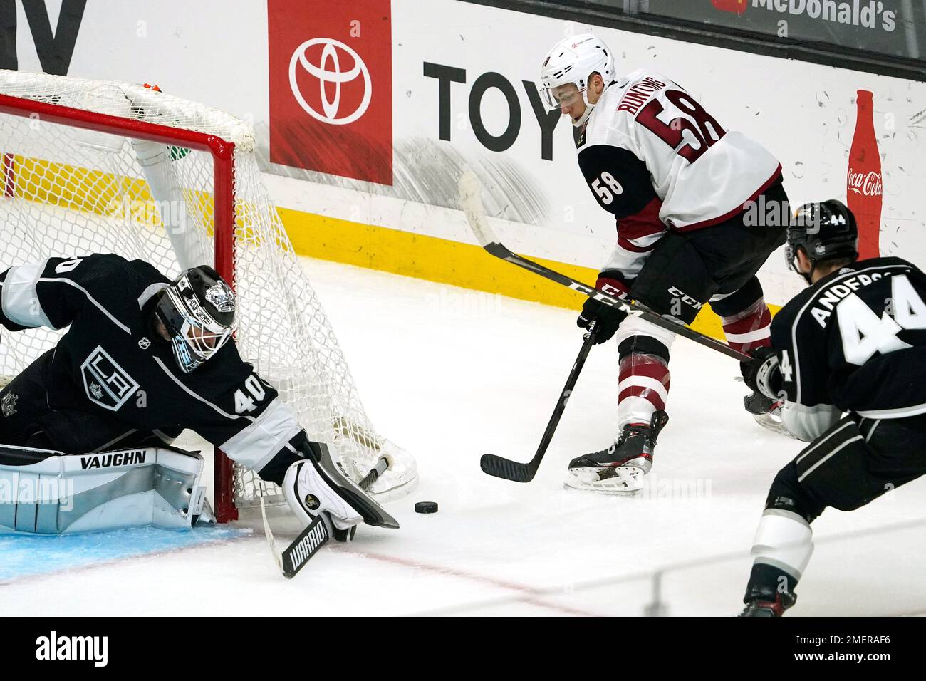 Arizona Coyotes left wing Michael Bunting, center, tires to get a shot ...