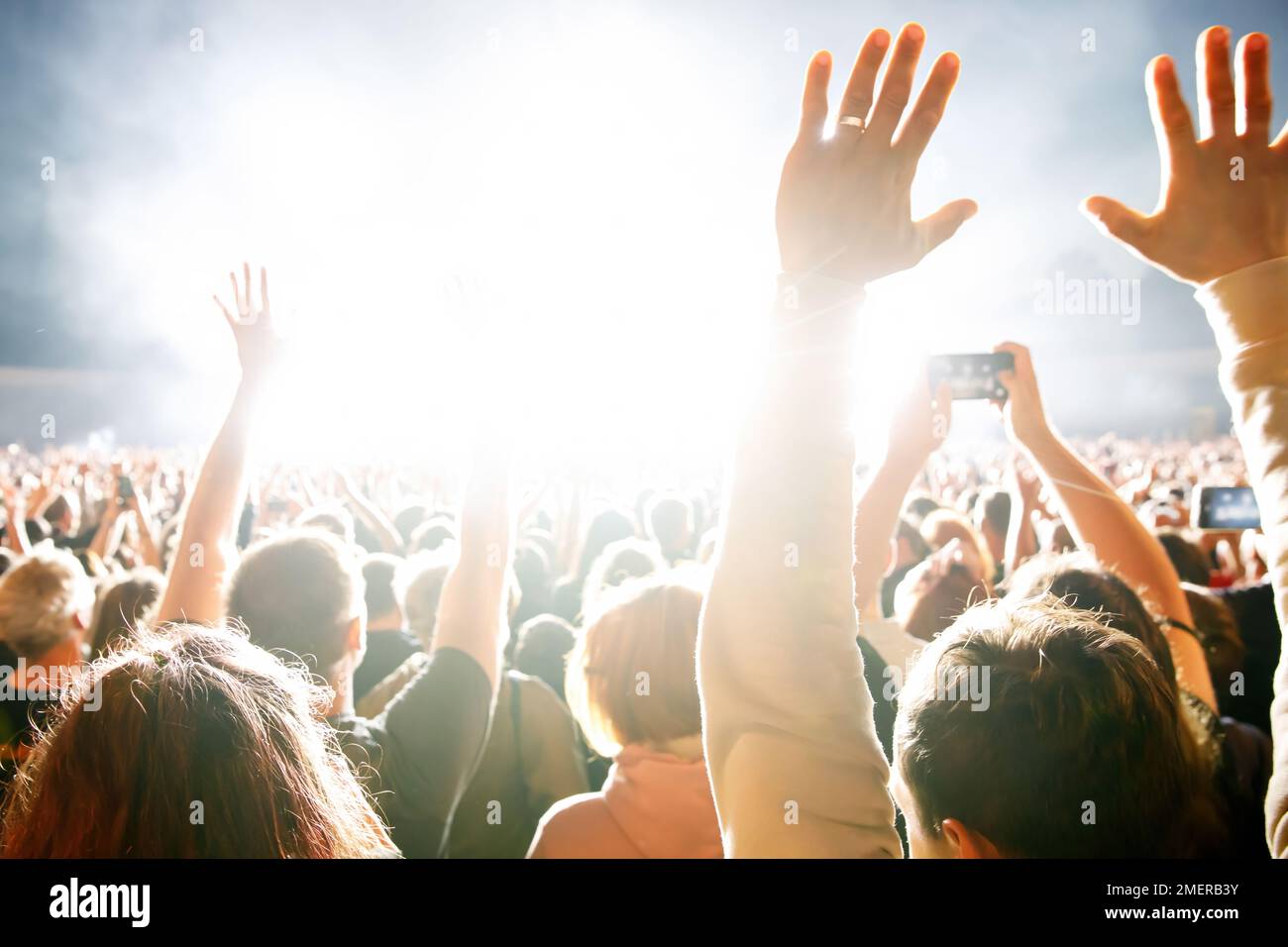 A crowd of people with raised arms during a concert Stock Photo - Alamy