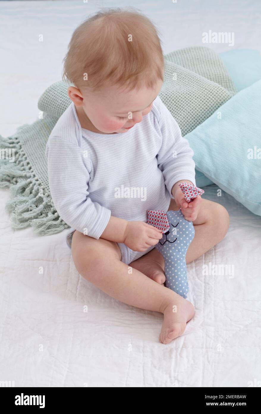 Baby boy holding rattle hi-res stock photography and images - Alamy