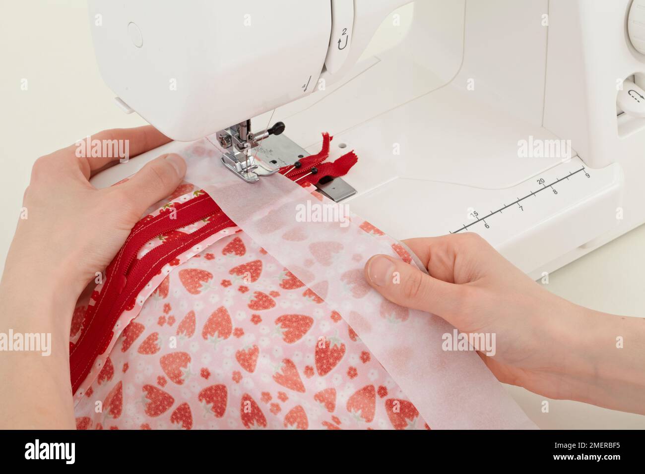 Making a water-resistant bag, stitching tissue paper down one side ...