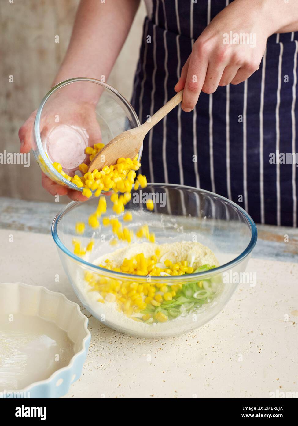 Corn bread, pouring corn into large bowl containing flour and chopped ...