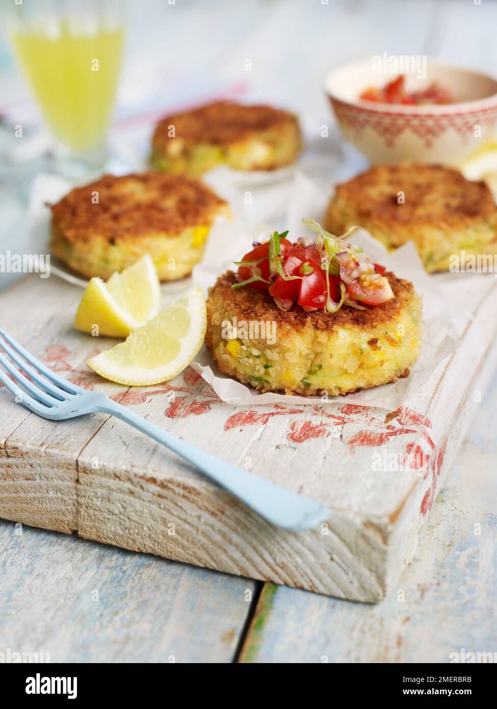 Fish cakes served with chopped tomato on top and slices of lemon Stock ...