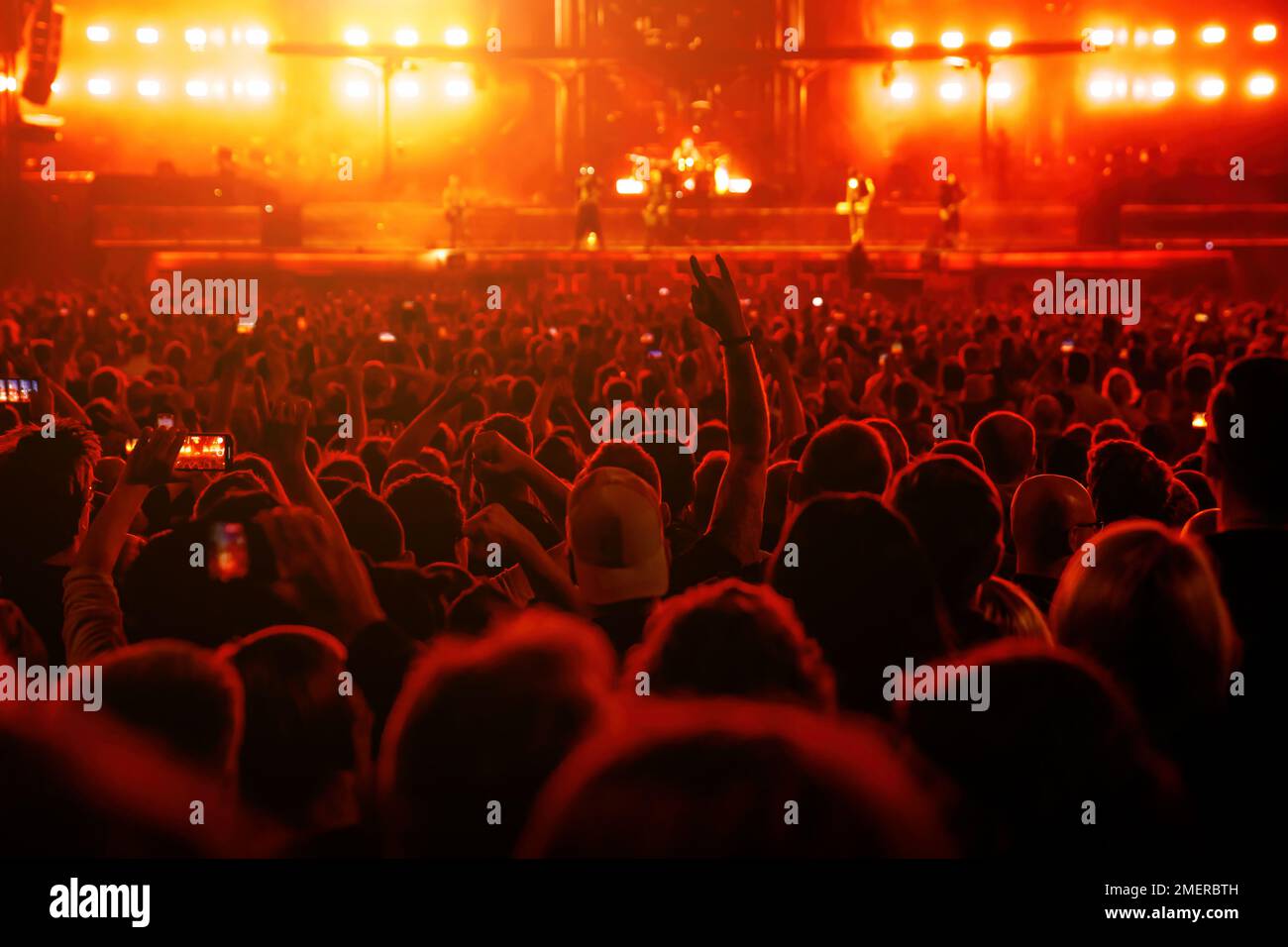A crowd of people with raised arms during a music concert with an ...