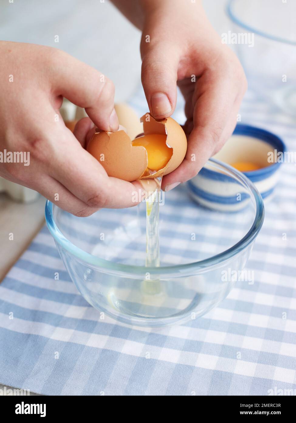 Breaking egg over bowl, dividing or separating eggs Stock Photo - Alamy