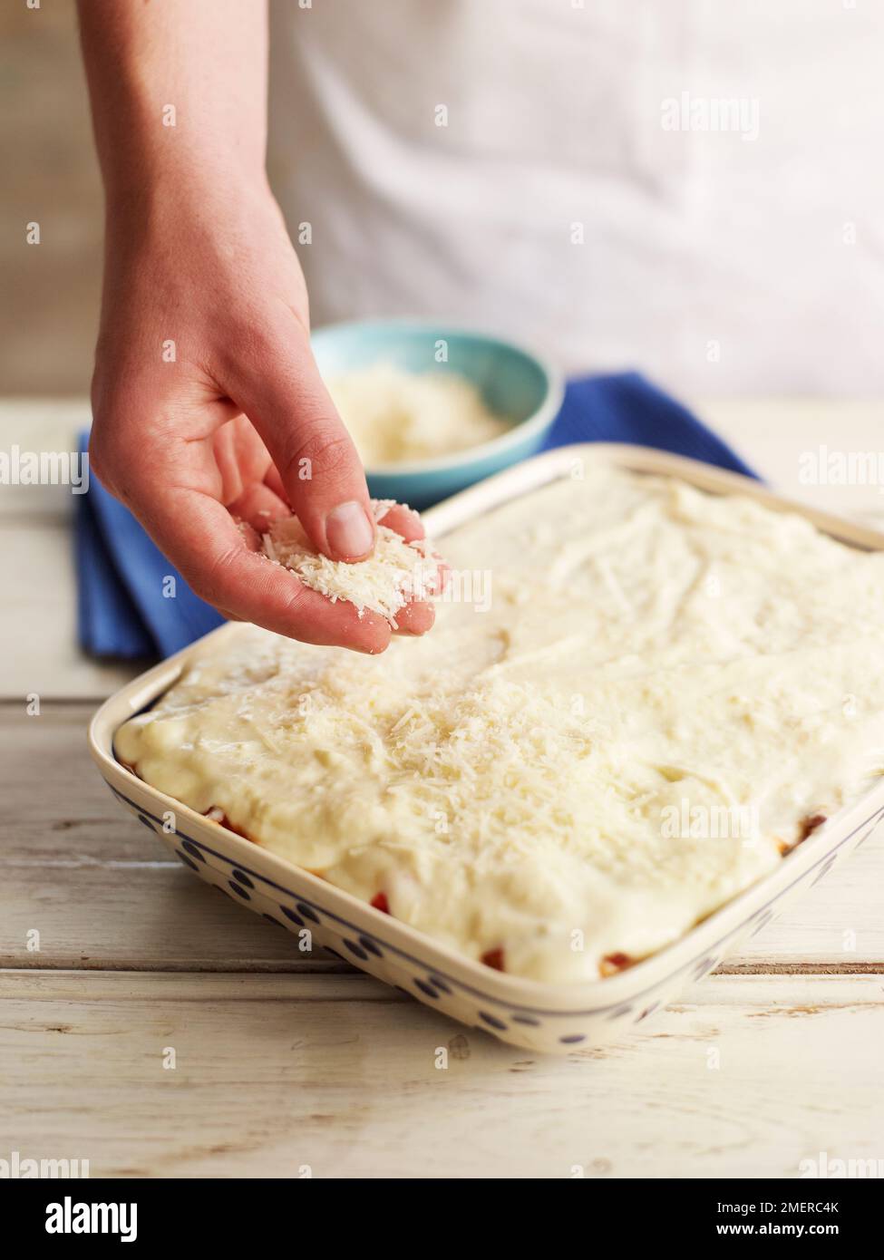 Making vegetable lasagne, topping with bechamel sauce and cheese Stock ...