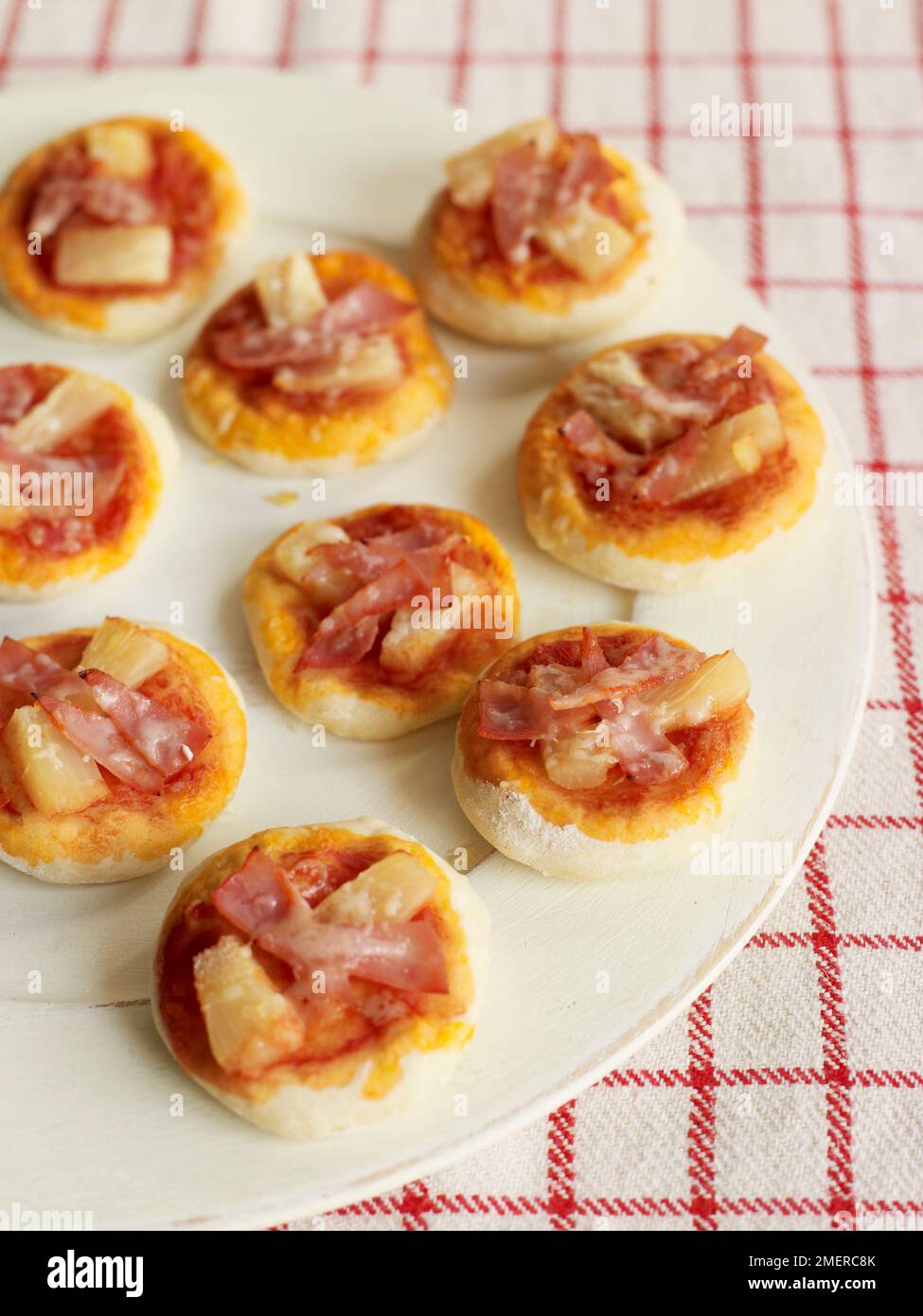 Mini pizzas topped with pineapple and ham, pizza hawaii Stock Photo - Alamy