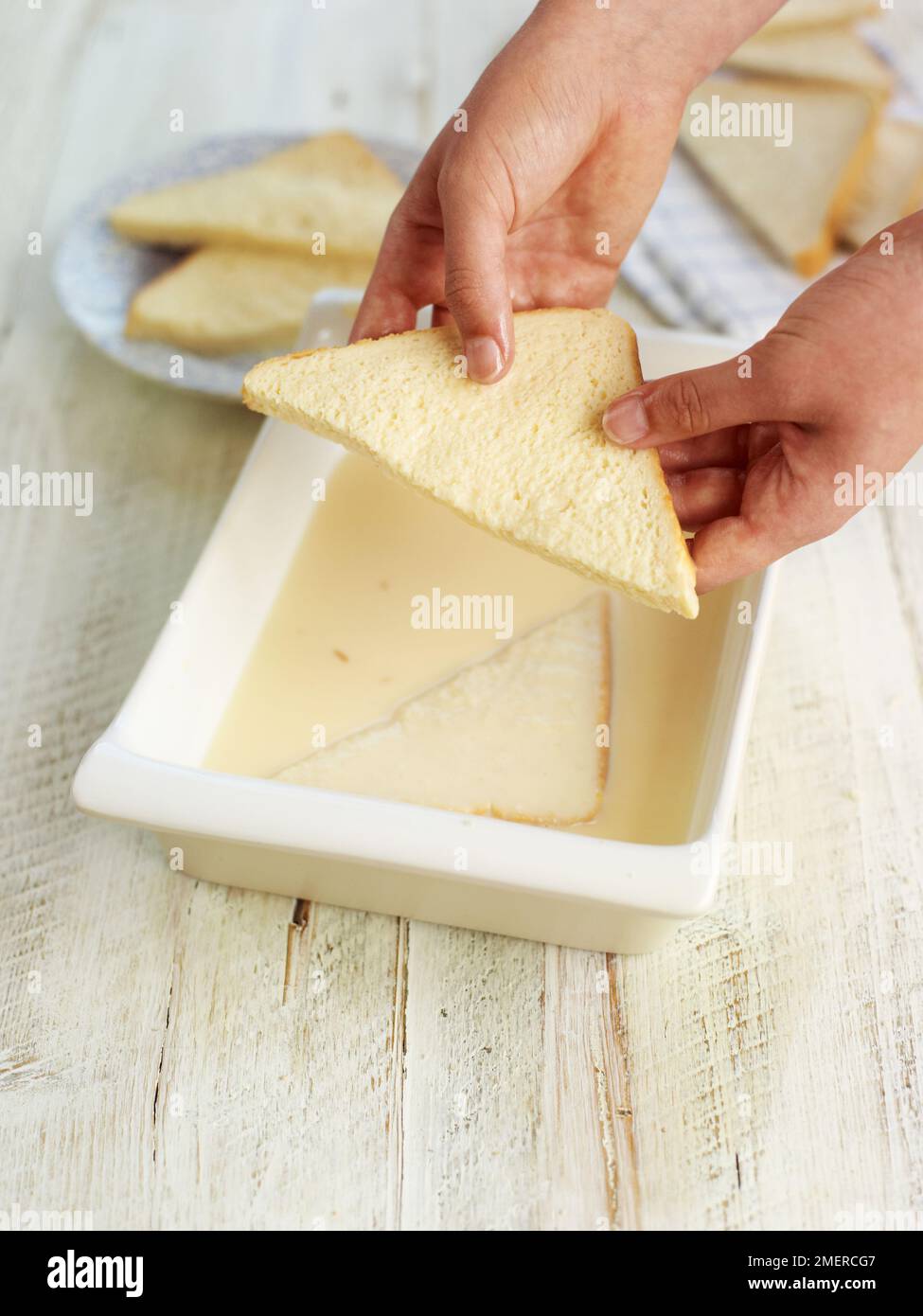 Making eggy bread, soaking triangles in milk and egg mixture Stock ...