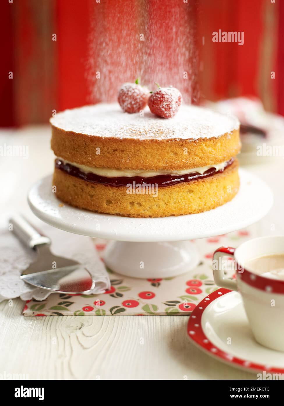 Sieving icing sugar on Victoria style sponge cake Stock Photo - Alamy