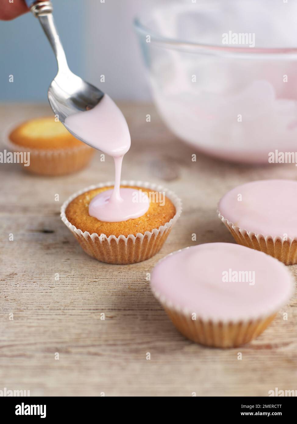 Adding icing mixture to top of cupcake Stock Photo - Alamy