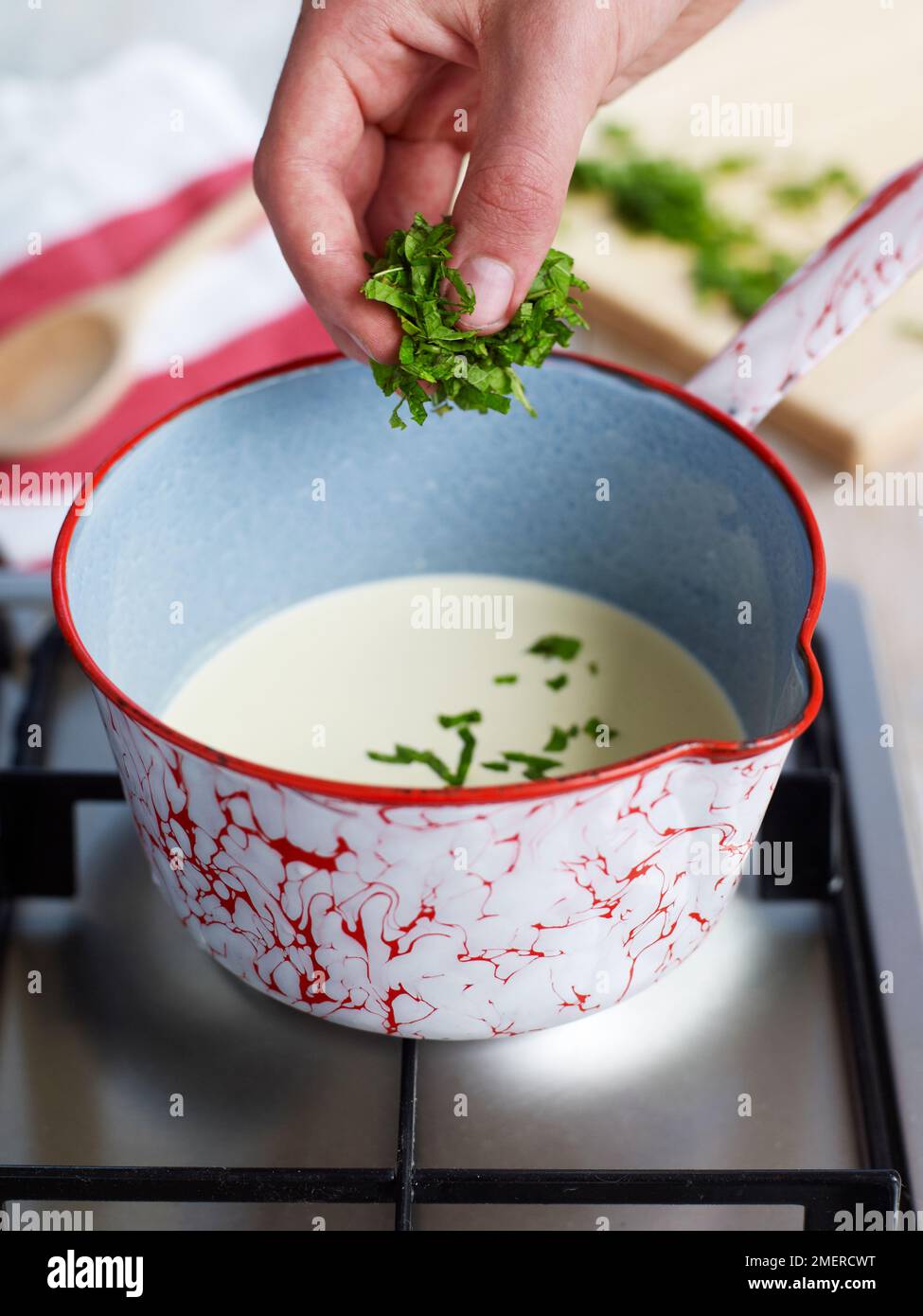Adding chopped mint to a saucepan of milk Stock Photo - Alamy