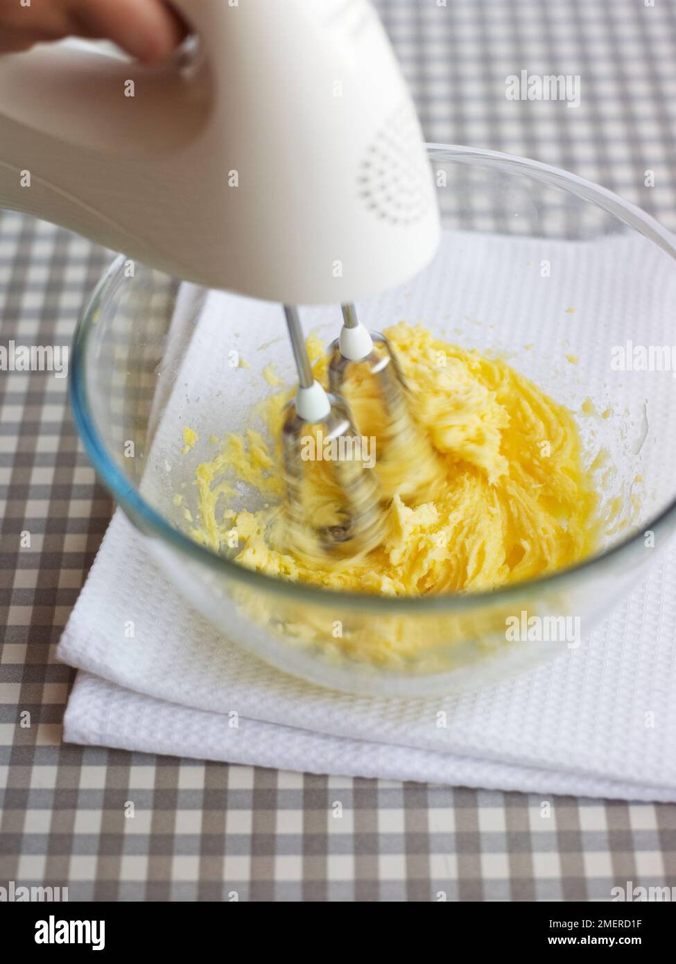 Using an electric whisk to beat cookie mixture Stock Photo - Alamy