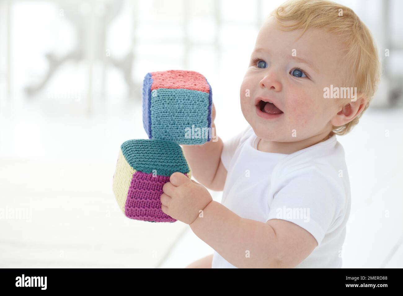 Baby boy sitting with knitted building blocks, 10 months Stock Photo ...