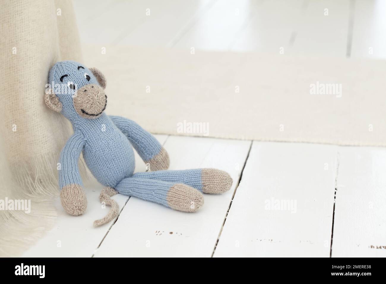 Knitted monkey toy sitting on floor Stock Photo - Alamy