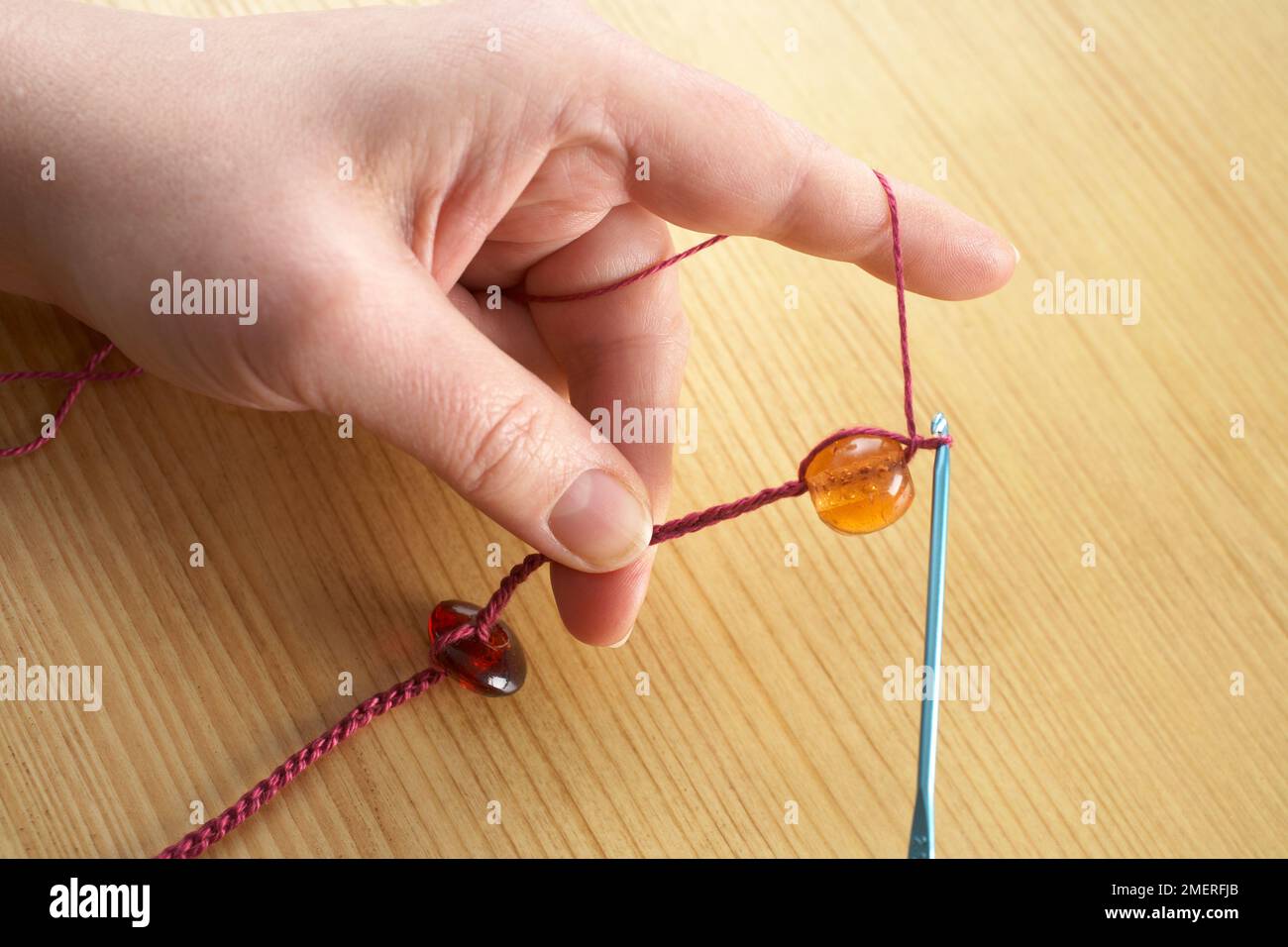 Making crochet necklace, Pulling the yarn through the loop to secure ...