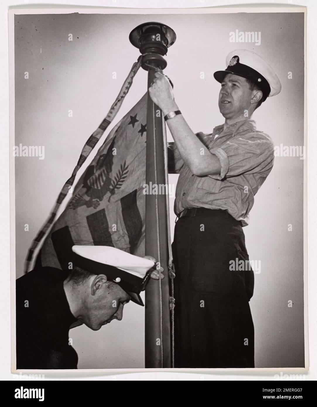 GMers Alfred Schultz and Percy Coolman fasten the Coast Guard ensign ...