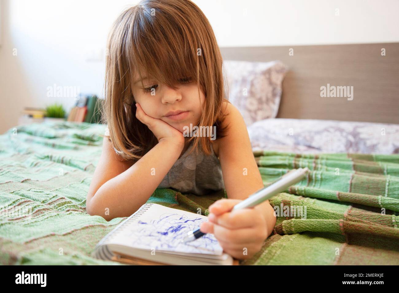 Little cute preschool girl lying on the bed in bedroom at home, she's ...